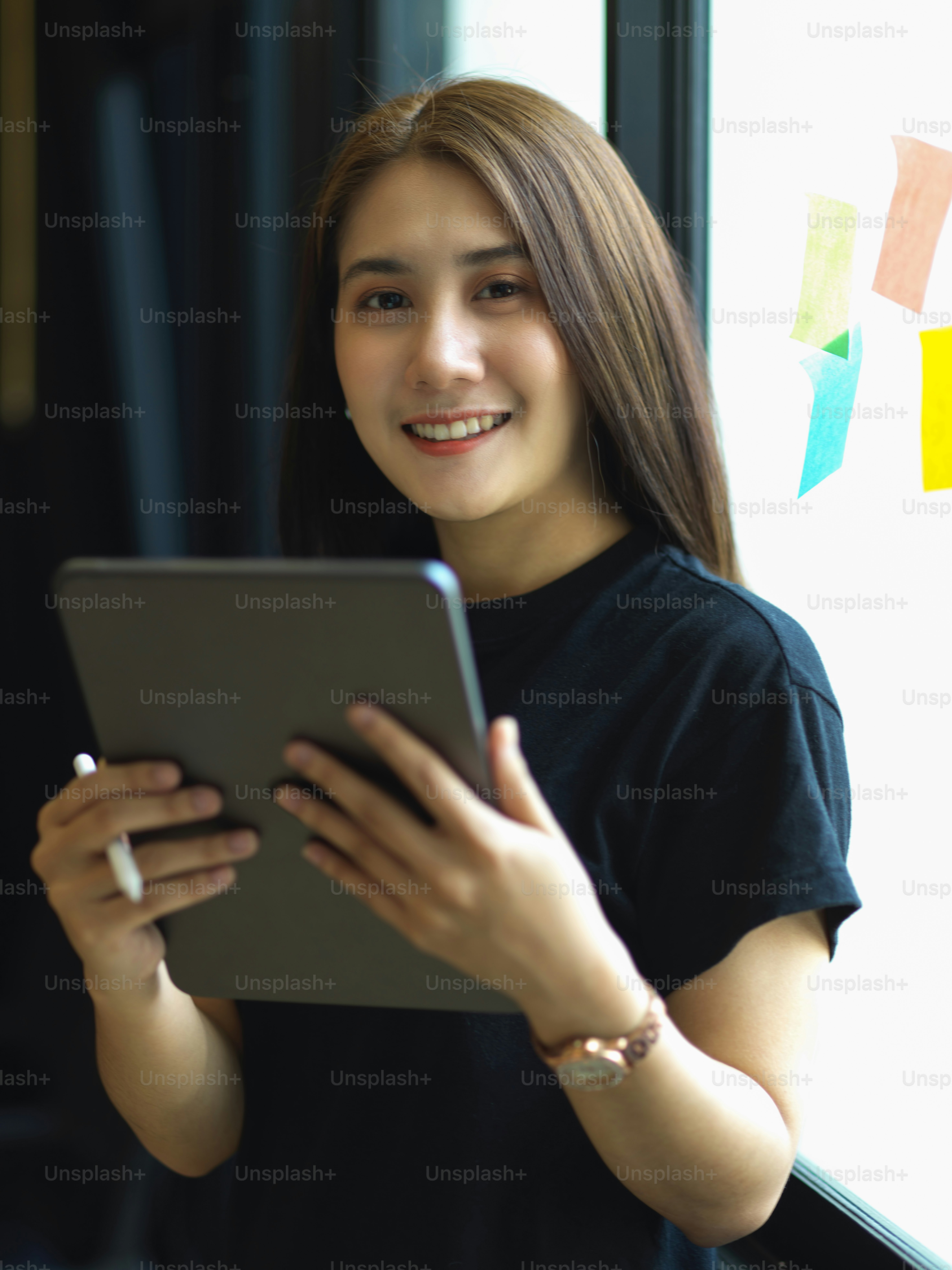 Portrait of female office worker smiling to camera while working with ...