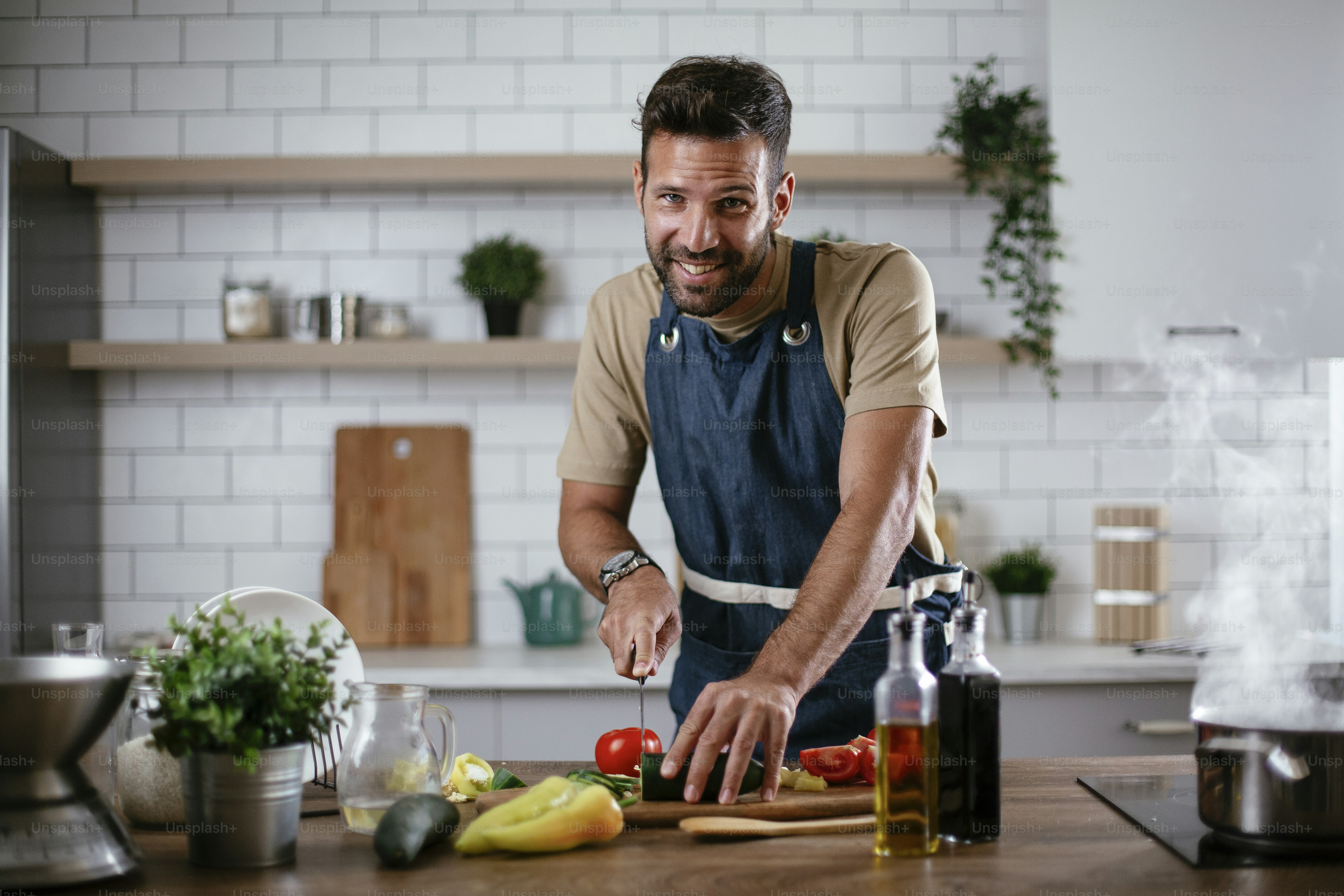 Portrait of handsome man in kitchen. Young man preparing salad. photo ...