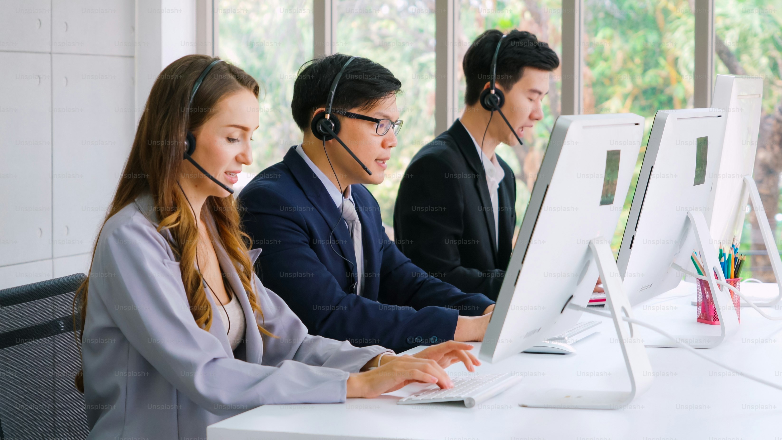 Business people wearing headset working in office to support remote ...