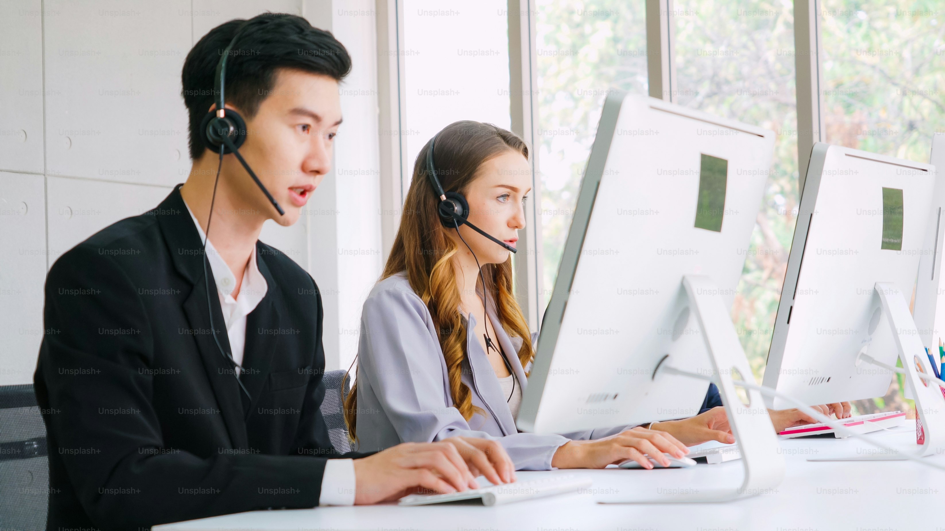 Business people wearing headset working in office to support remote ...