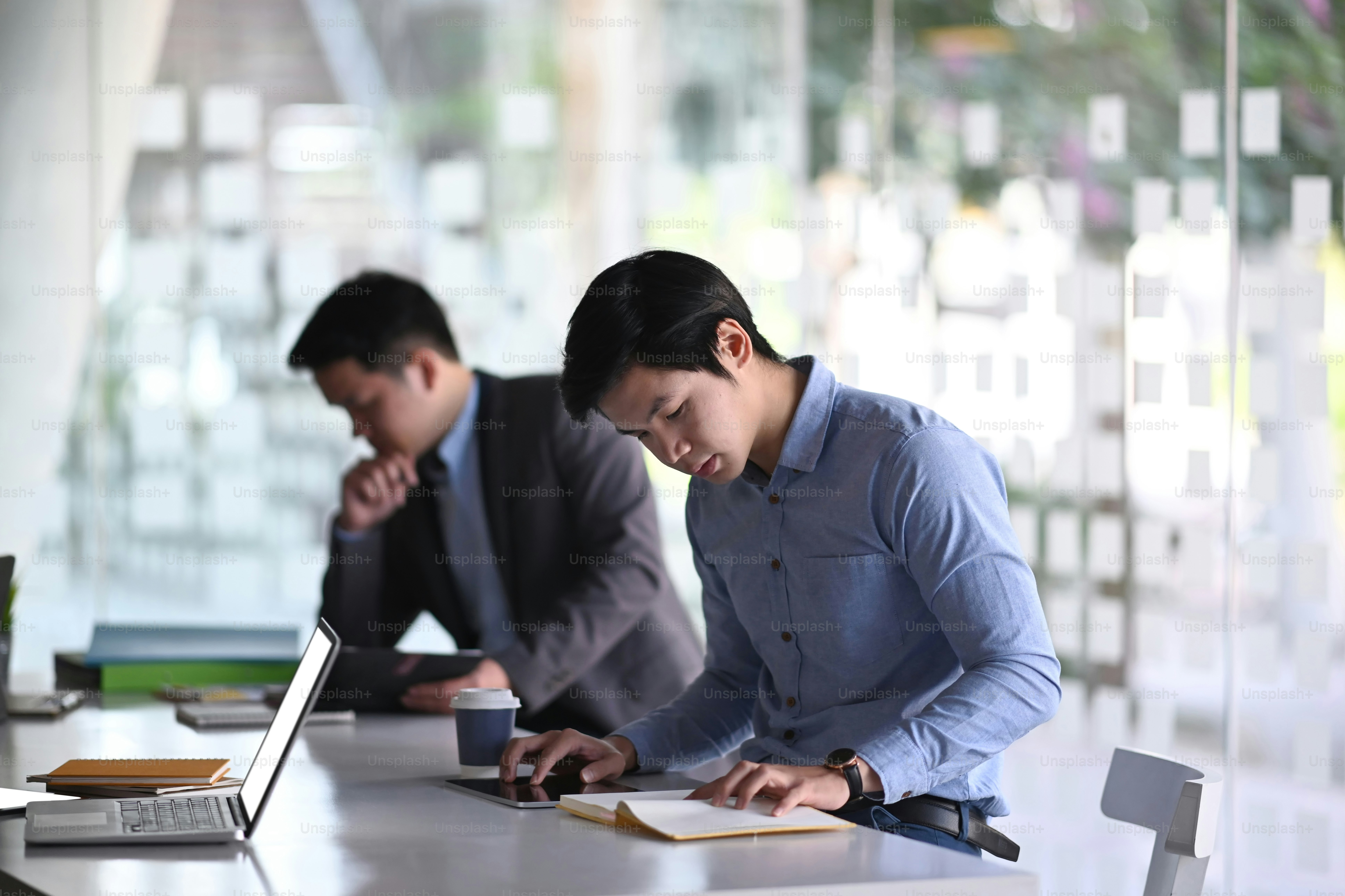 Two businessman concentrate working in modern office. photo – Indoors ...