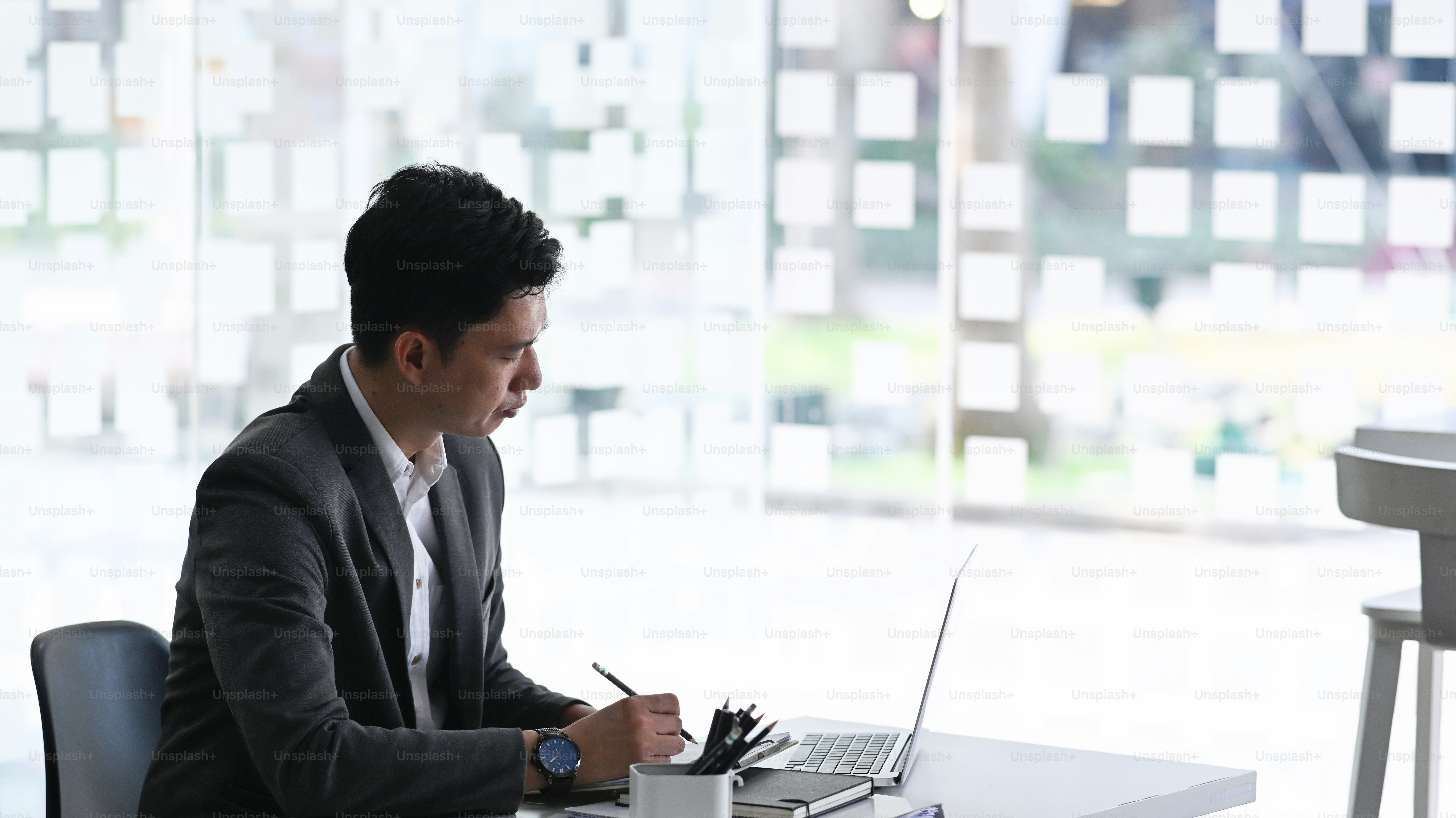Confident businessman working with laptop computer and analyzing ...