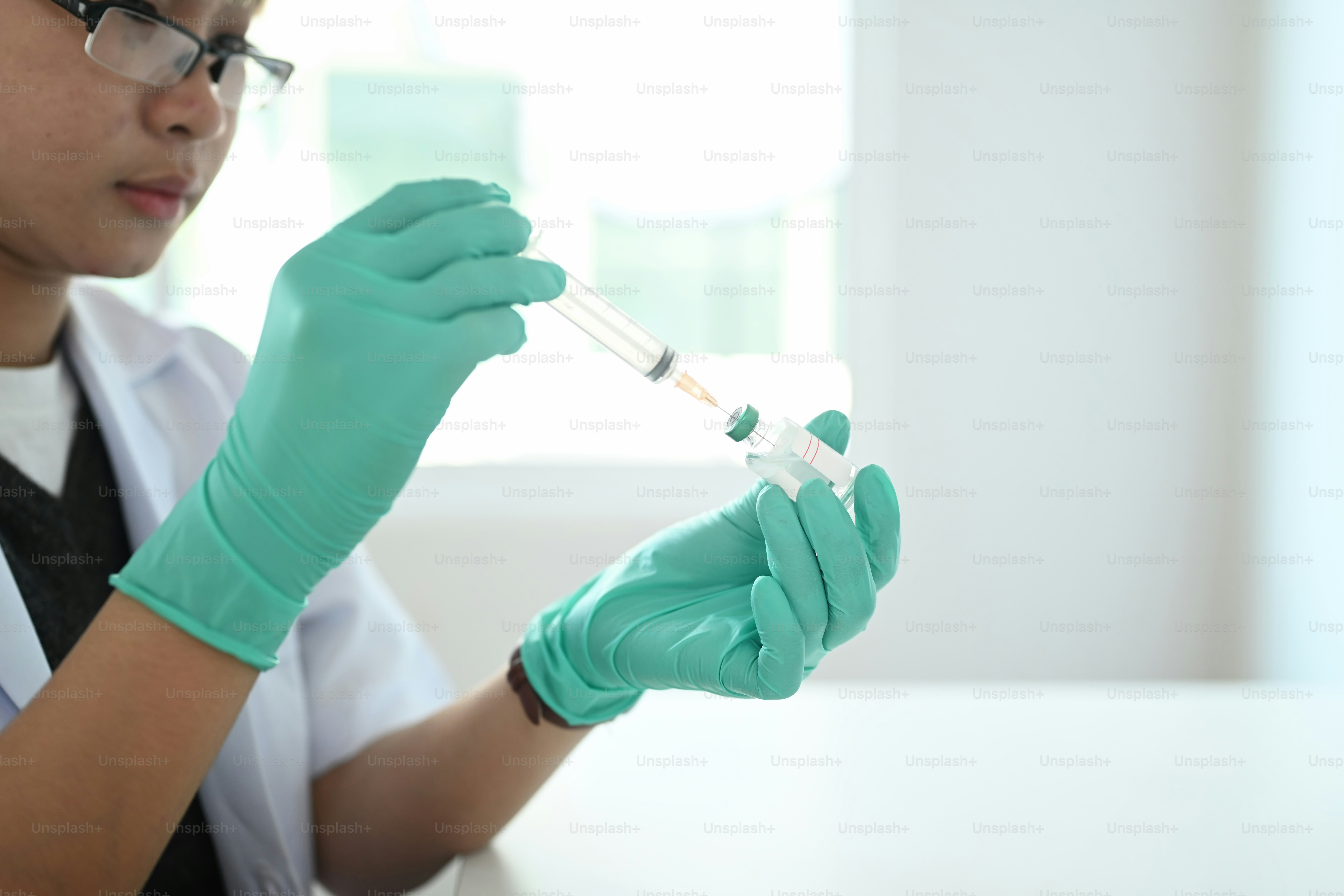 Close up view of doctor holding an injection syringe and vaccine. photo ...