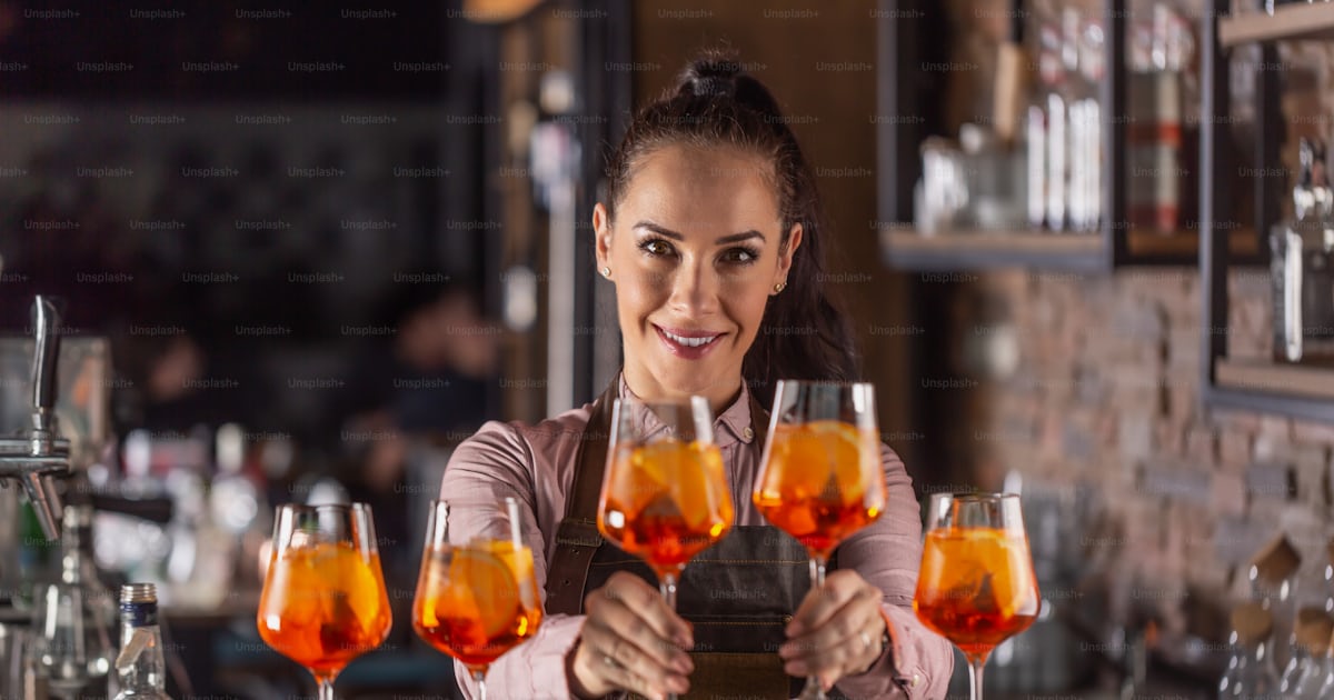 갓 만든 Spritz 칵테일 잔을 제공하는 아름다운 웨이트리스 사진 Unsplash의 바 카운터 이미지