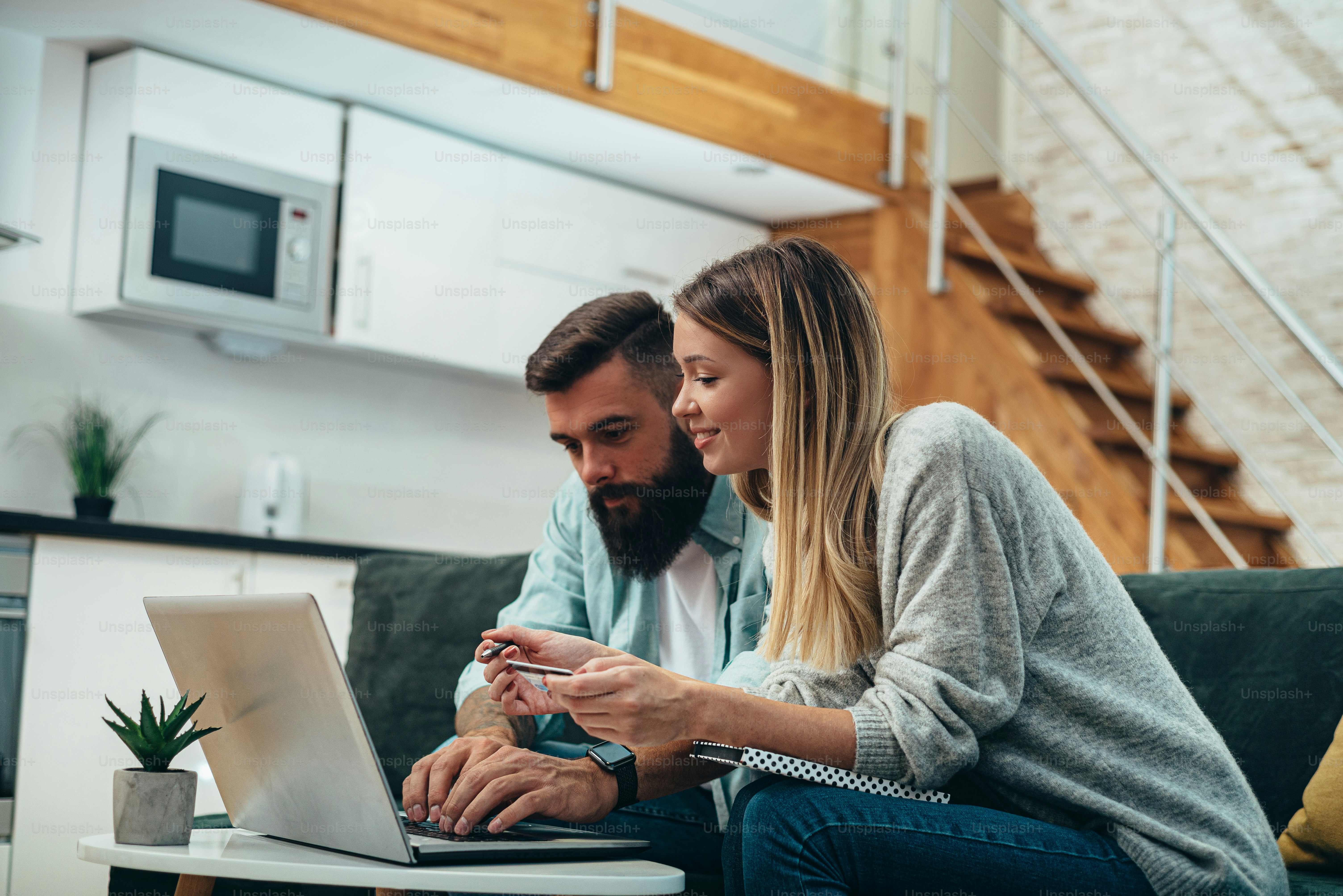 Shot of a young couple using a credit card and laptop for online ...