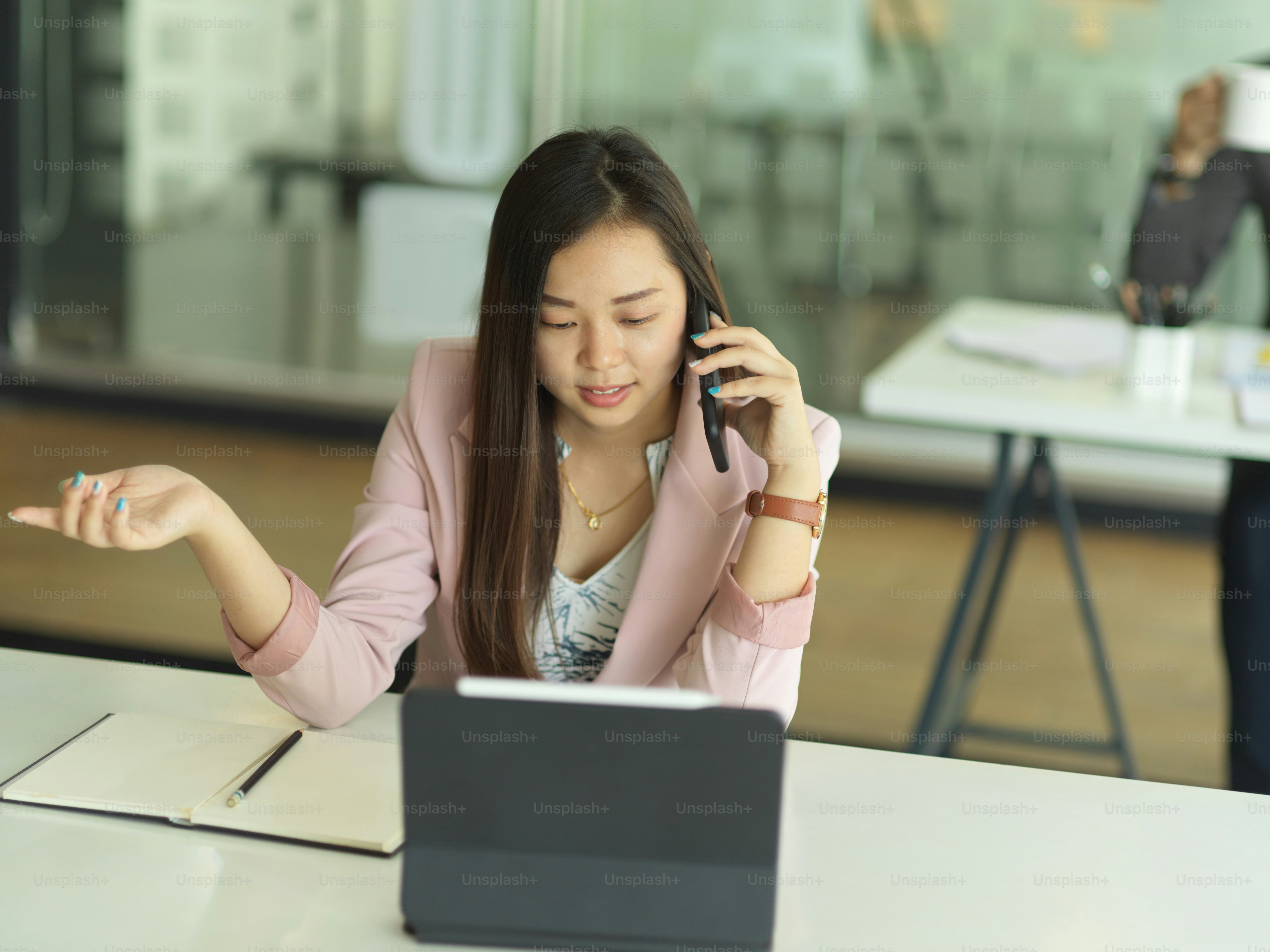 Portrait of businesswoman talking on the phone while working with ...