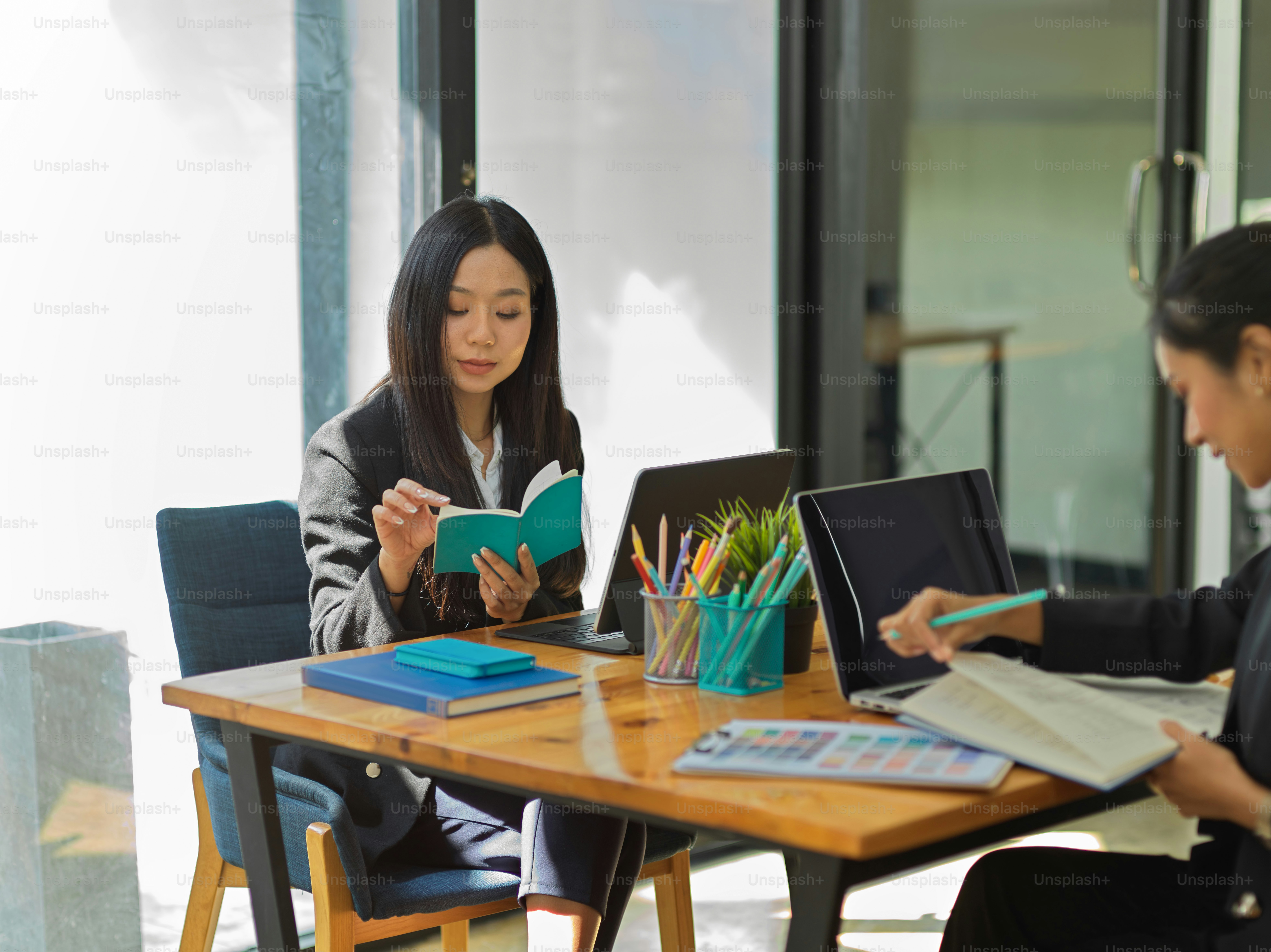 Cropped shot of two female office workers working together while ...