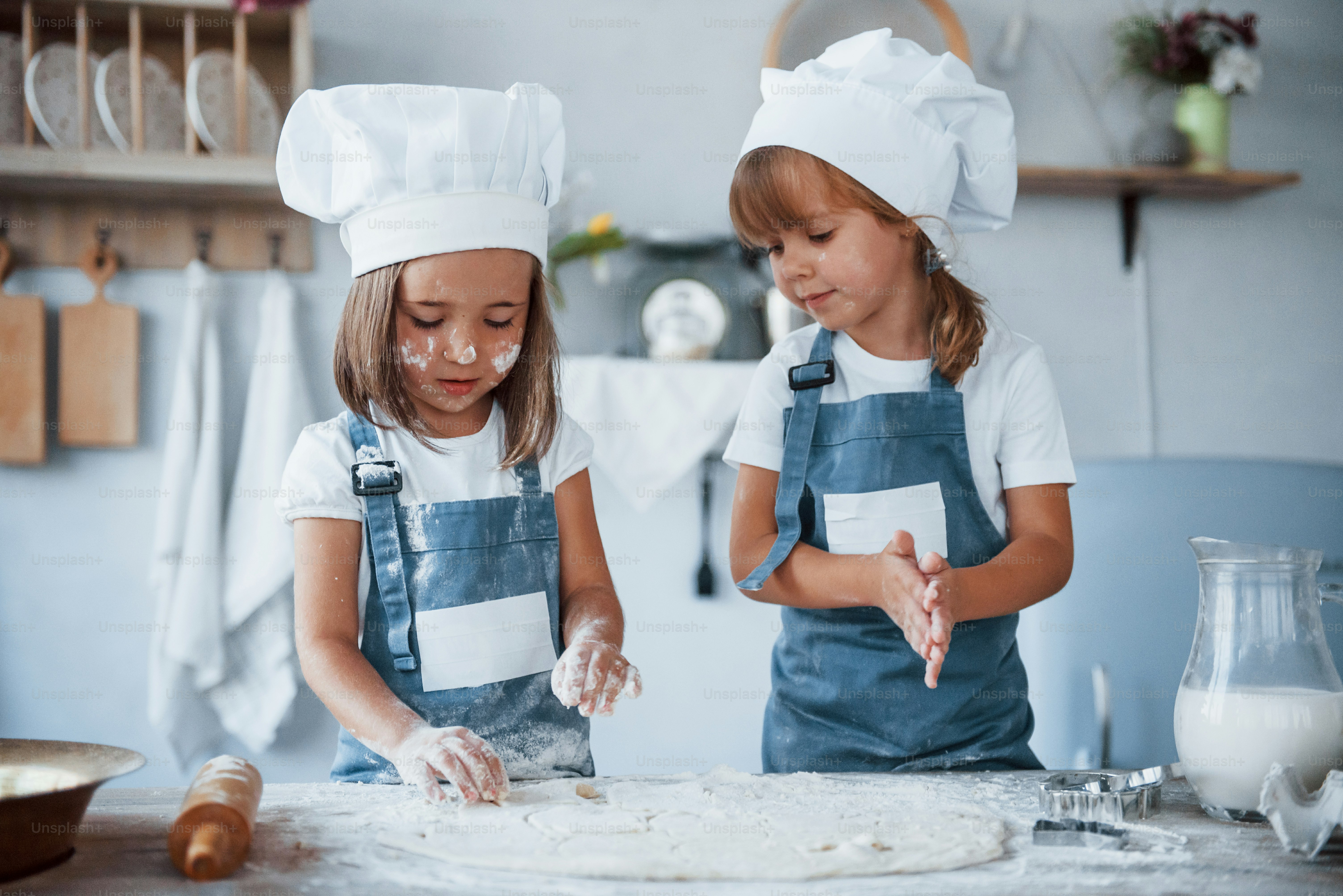 Concentrating at cooking. Family kids in white chef uniform preparing ...