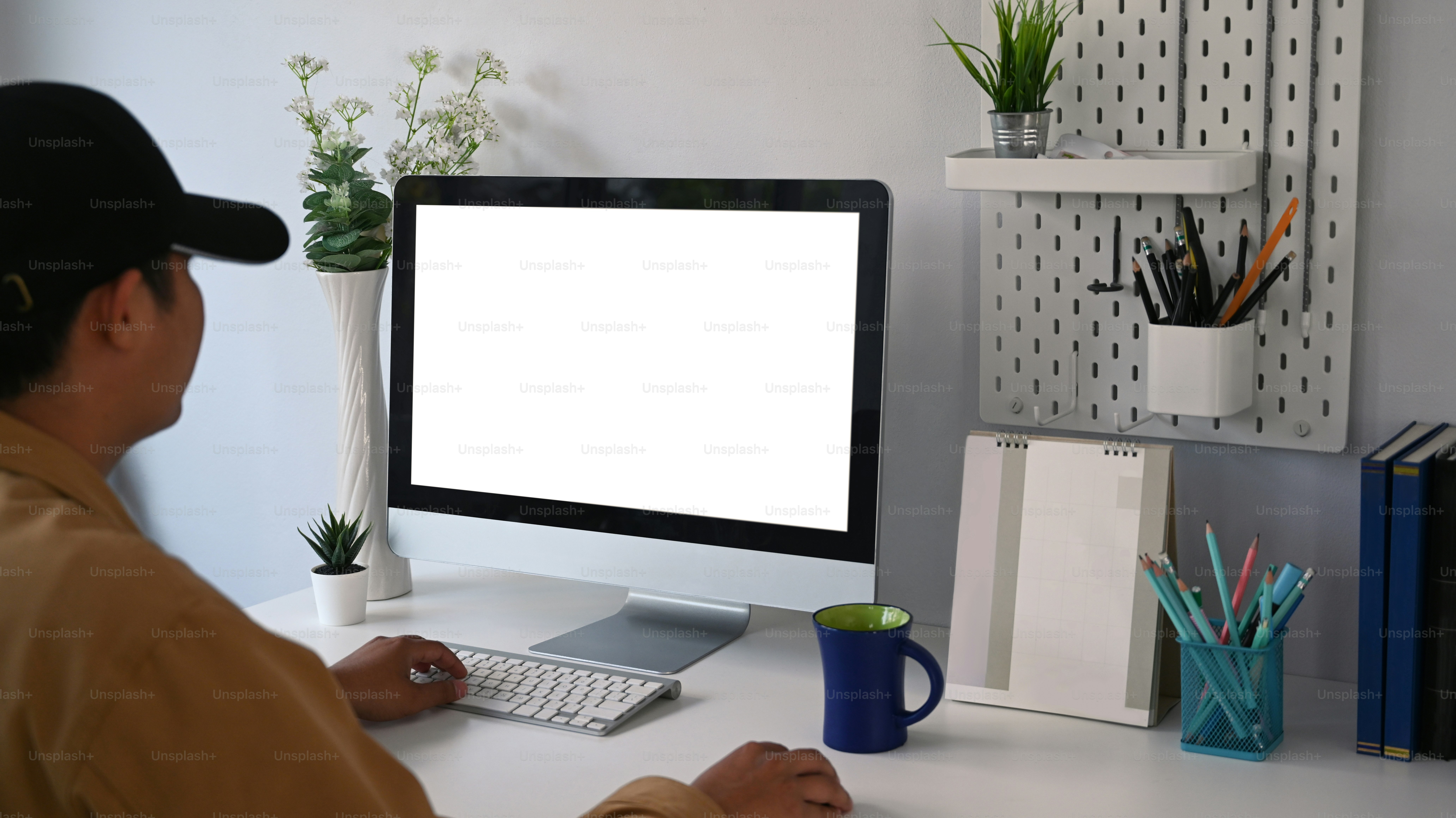 Young man freelancer sitting at modern workplace and working online ...