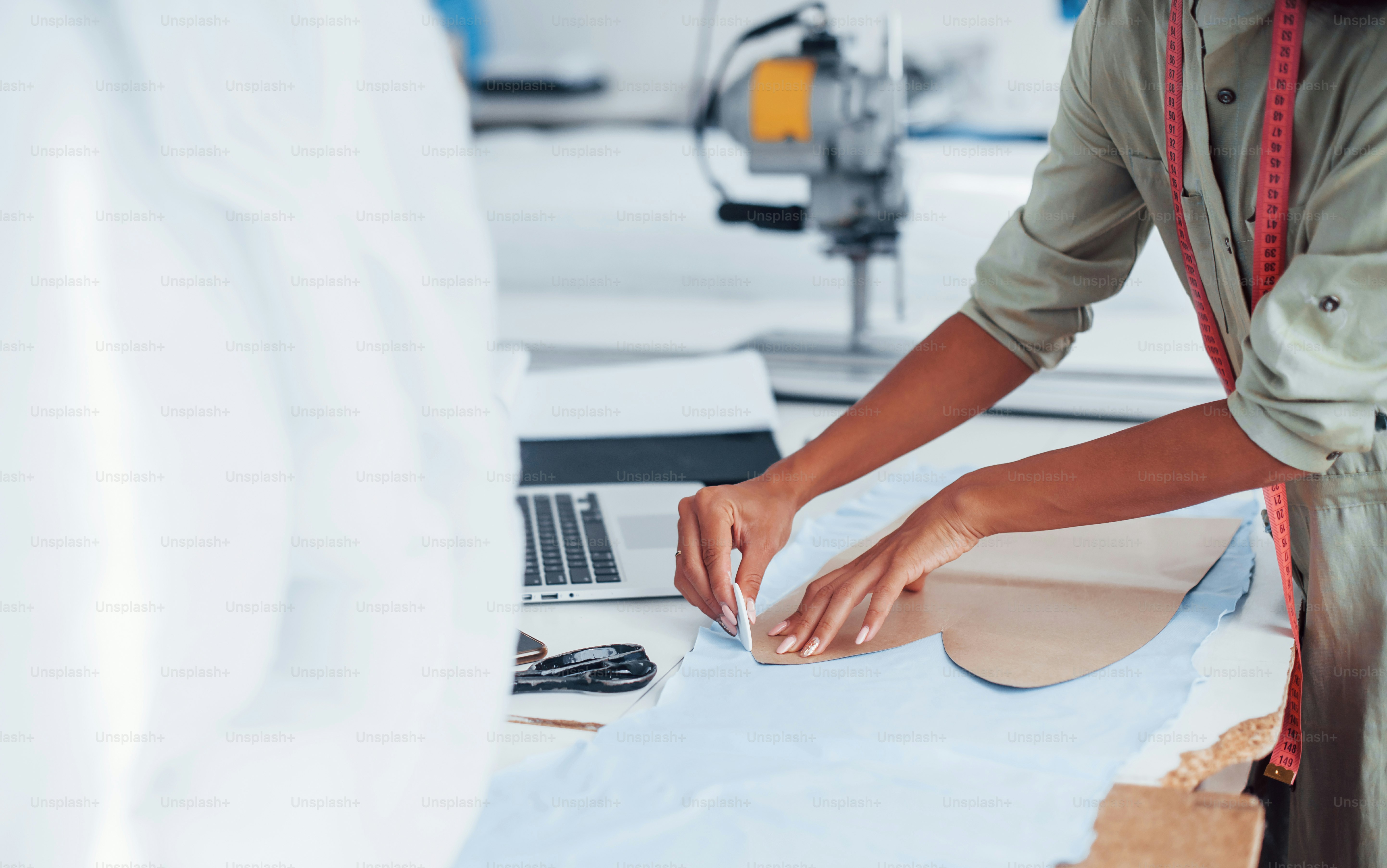 Busy with cloth. Beautiful female worker is in the sewing factory ...