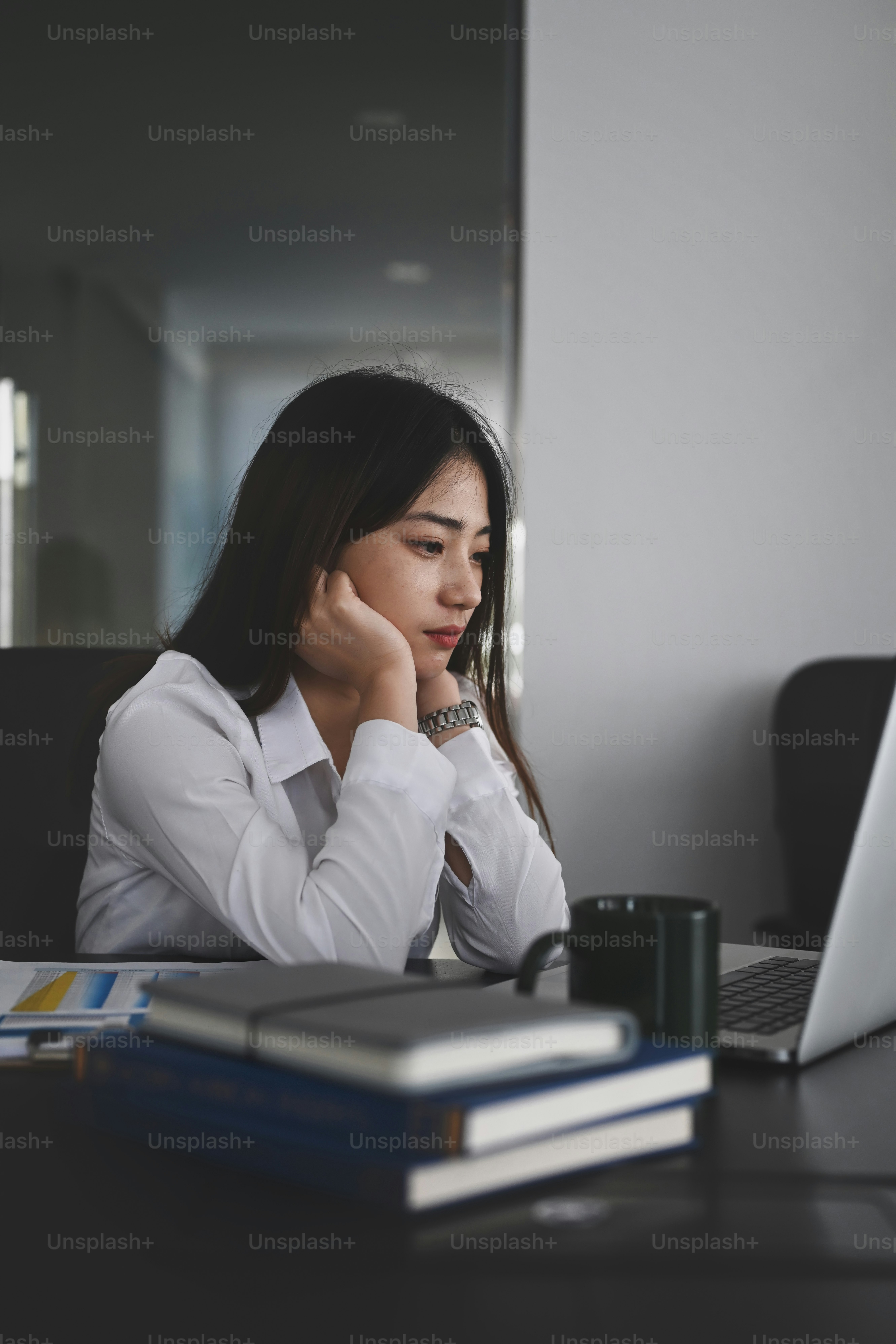 Portrait of focused young businesswoman looking at screen of computer ...