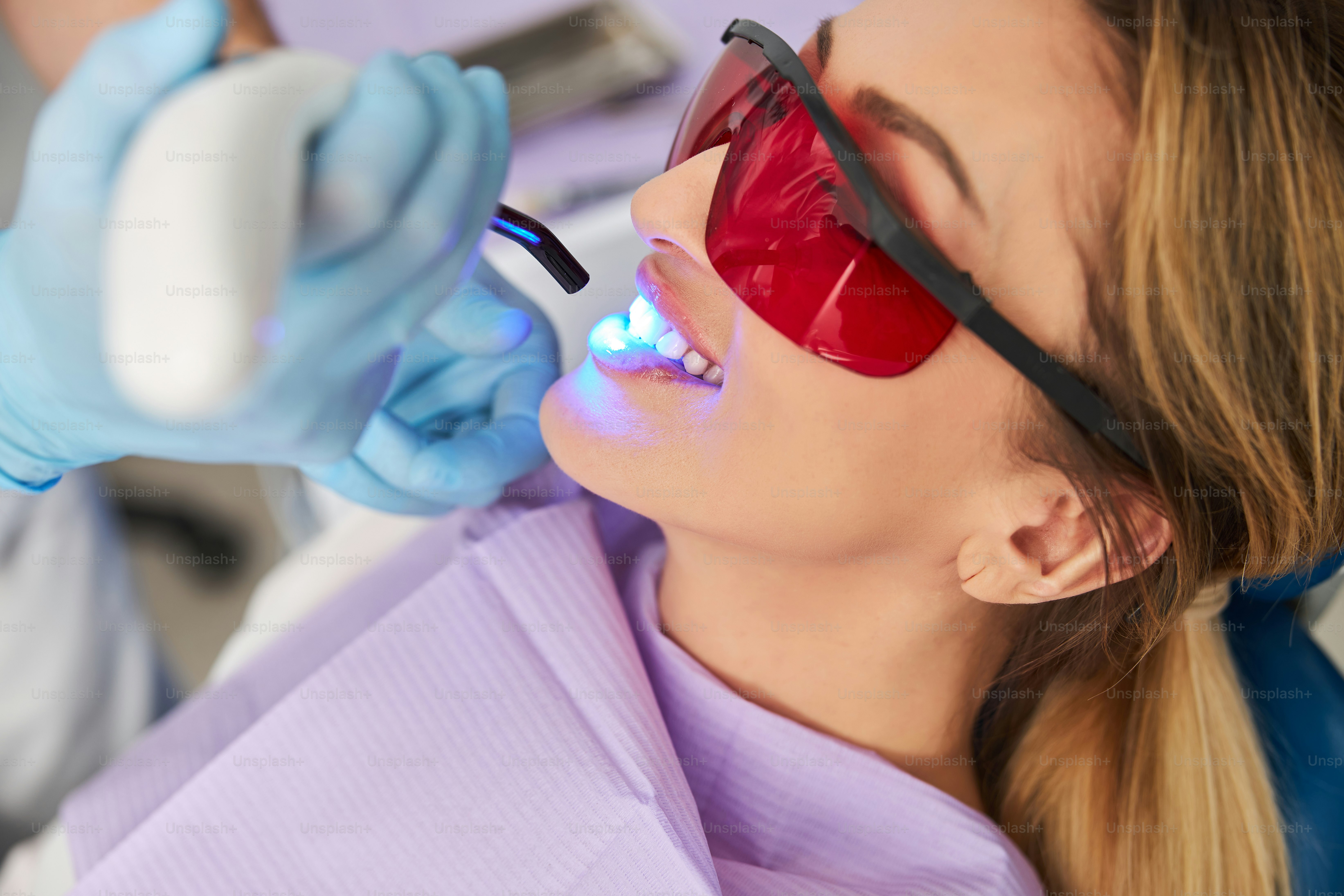 Woman covering her eyes with red plastic glasses and smiling while ...