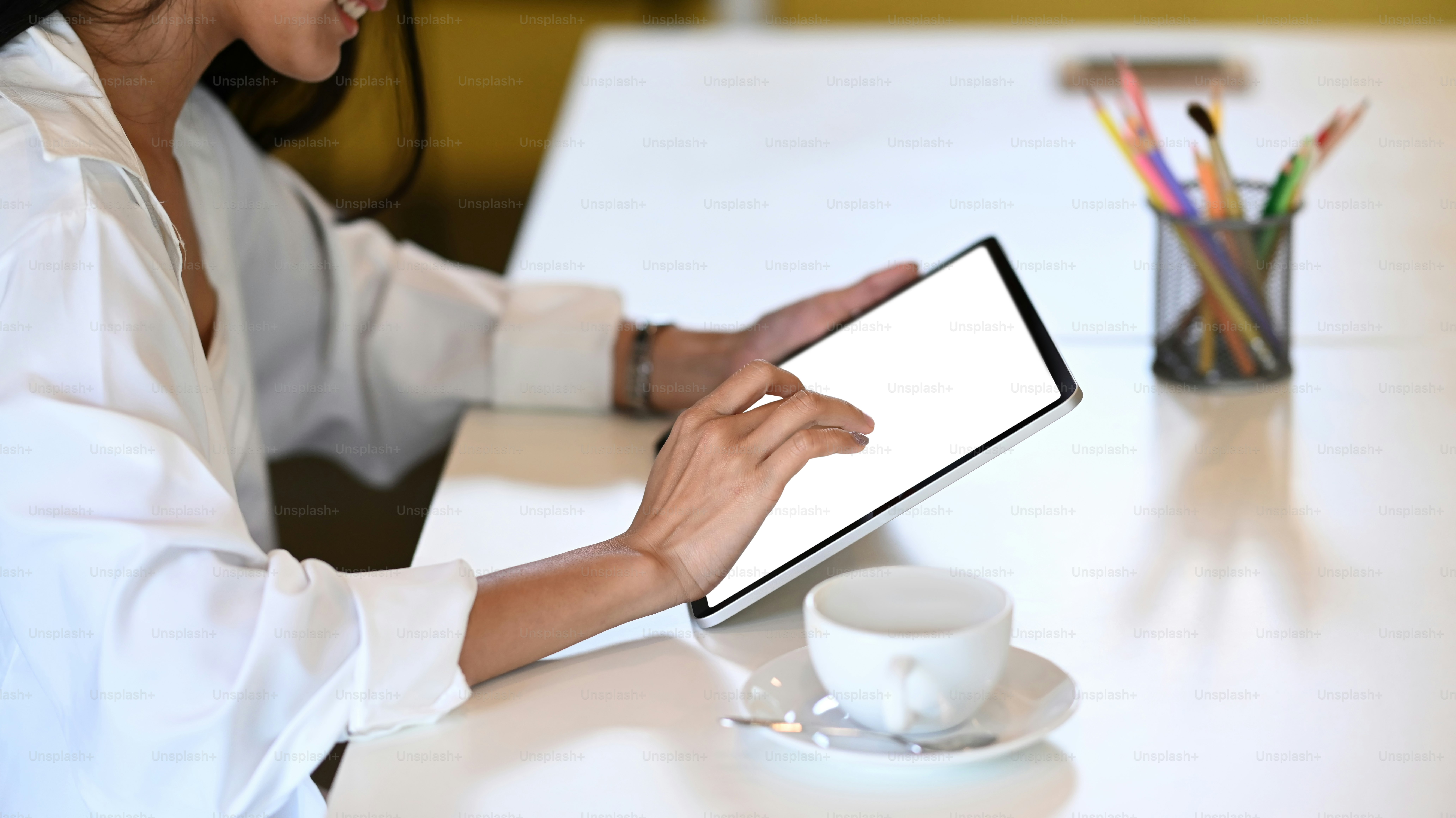 Cropped shot of smiling young woman designer using digital tablet in ...