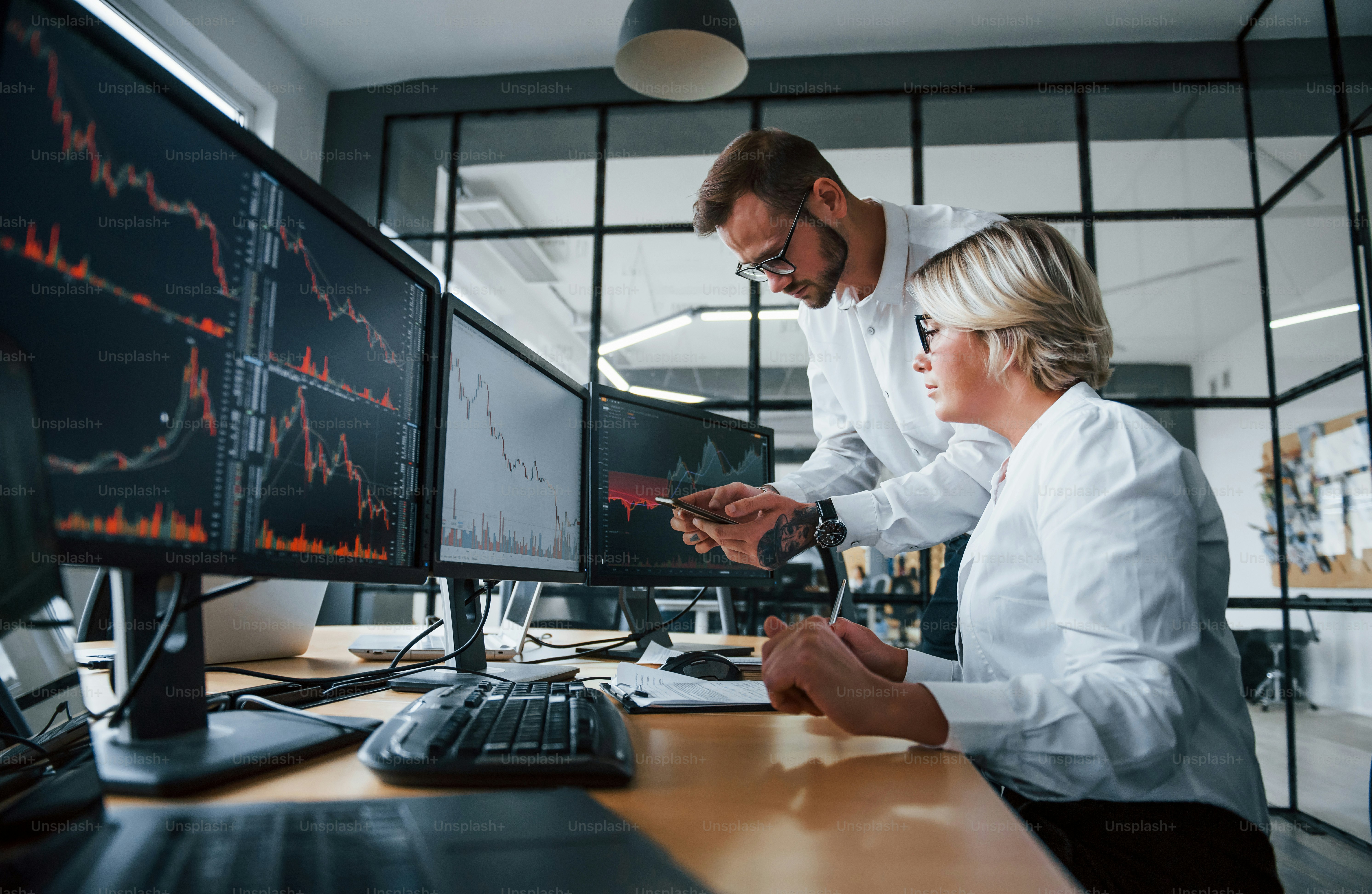 Analyzing information together. Two stockbrokers in formal clothes ...