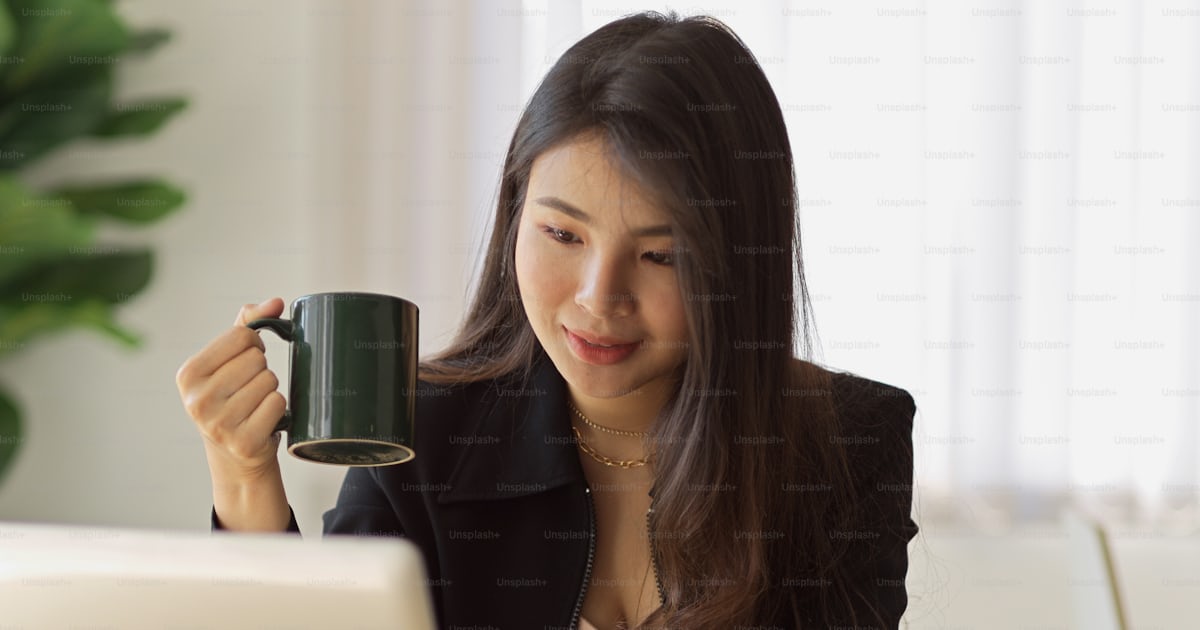 커피 컵을 들고 현대적인 사무실에서 노트북으로 작업하는 사업가의 초상화 사진 Unsplash의 테이블 이미지