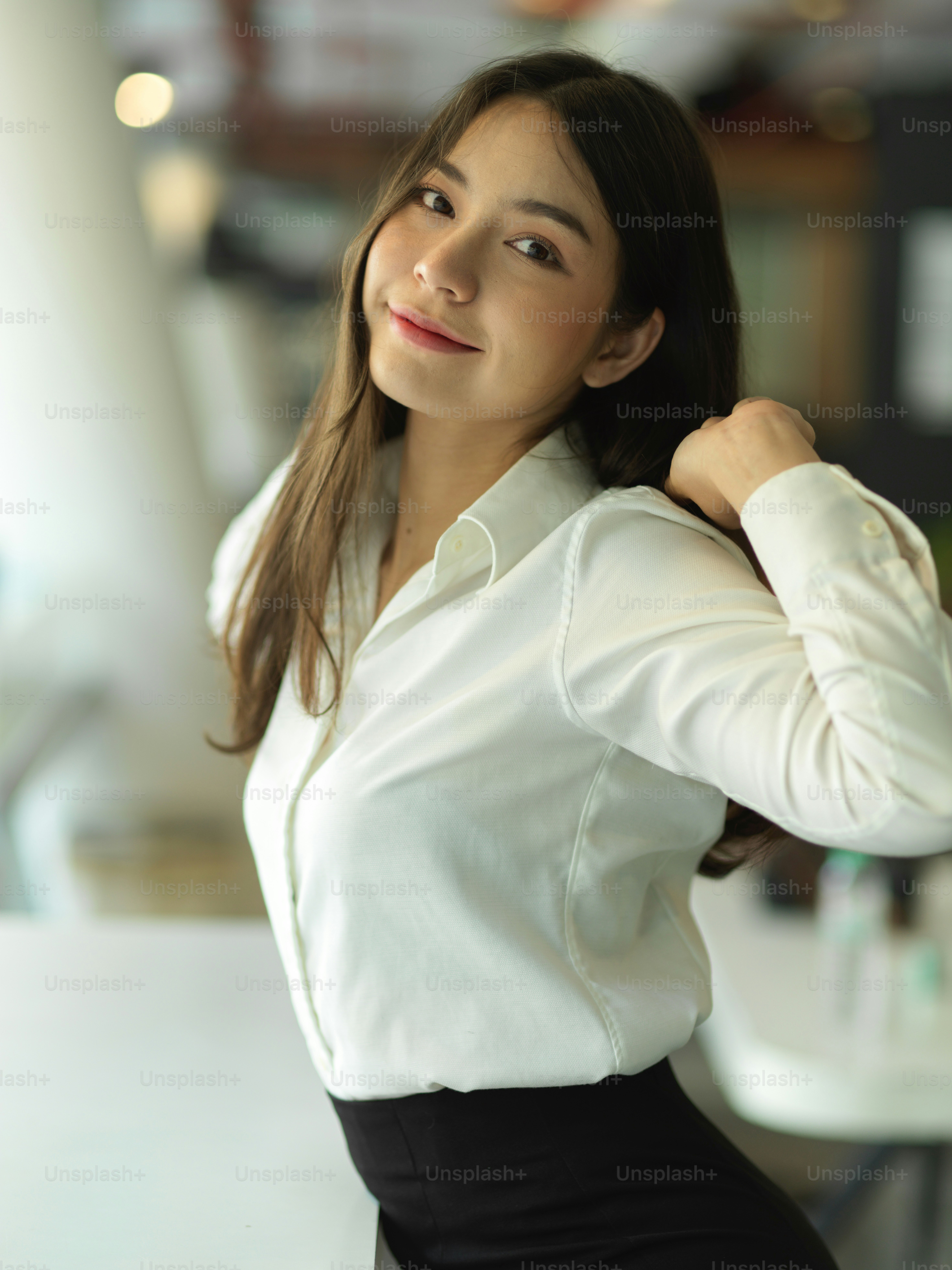 Portrait of young beautiful female office worker smiling to camera ...
