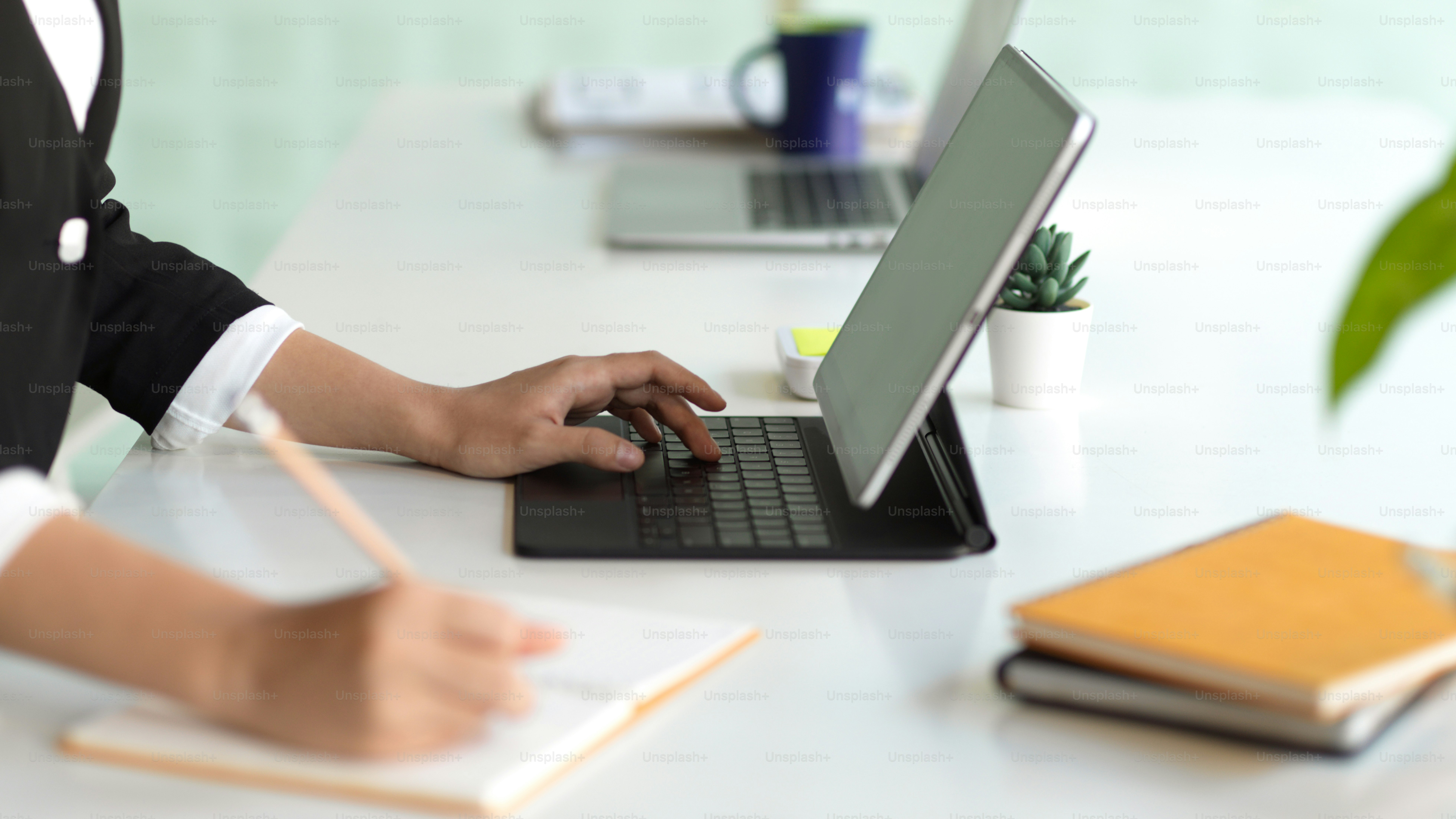 Side view of female hands typing on laptop keyboard on wooden office ...