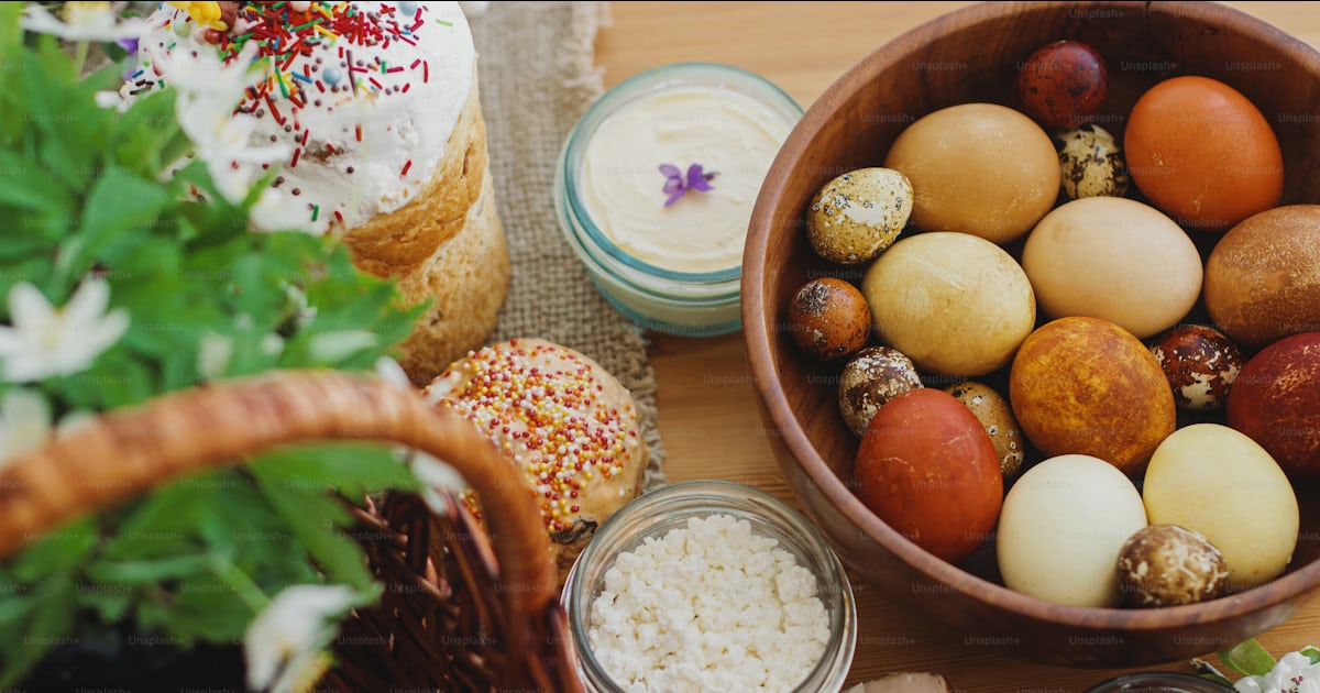 세련된 부활절 달걀 수제 부활절 빵 고리 버들 바구니에 담긴 맛있는 전통 부활절 음식 소박한 테이블의 린넨 냅킨에 피는 봄