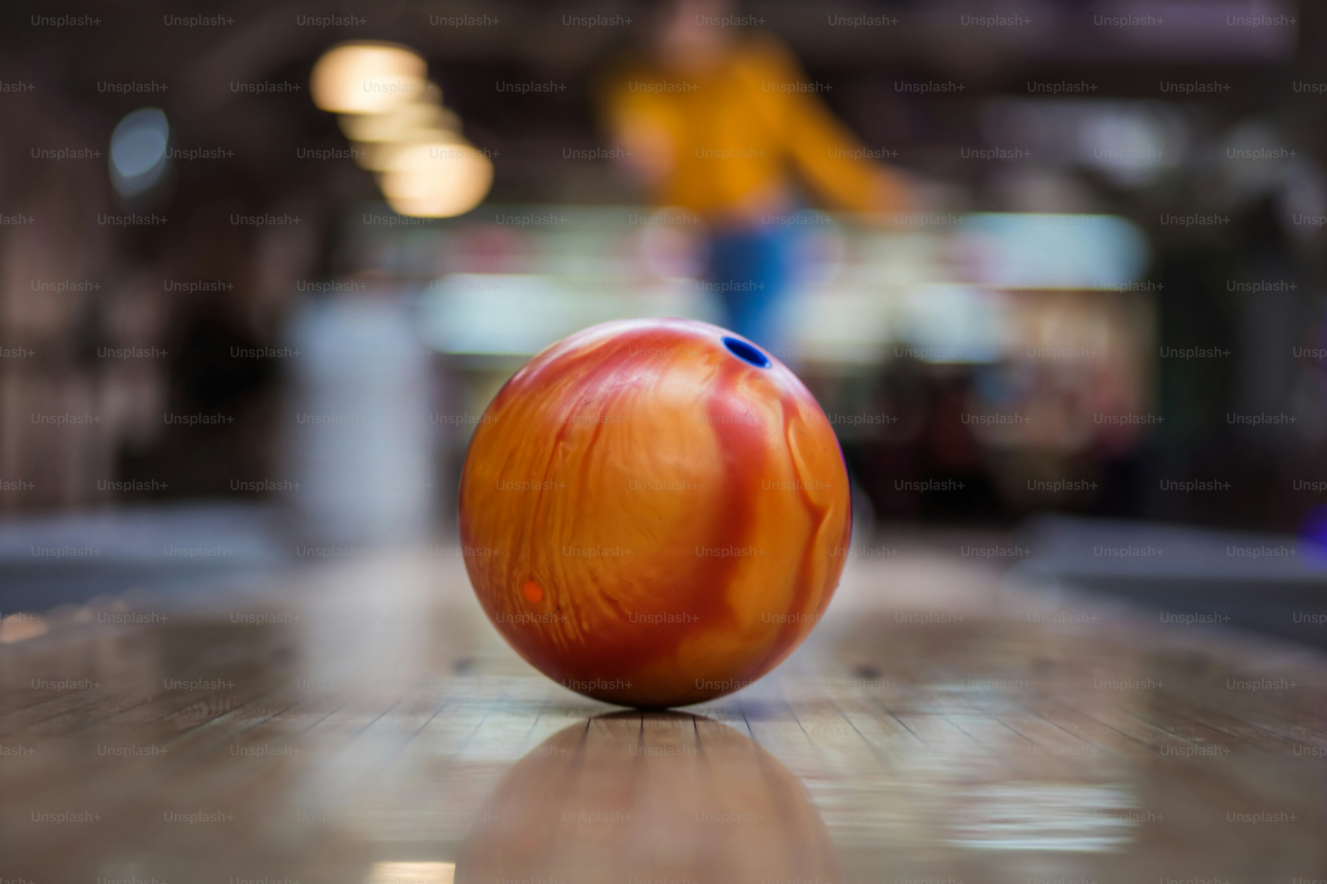 Woman playing bowling game. Focus is on bowler. photo – Bowling ball ...