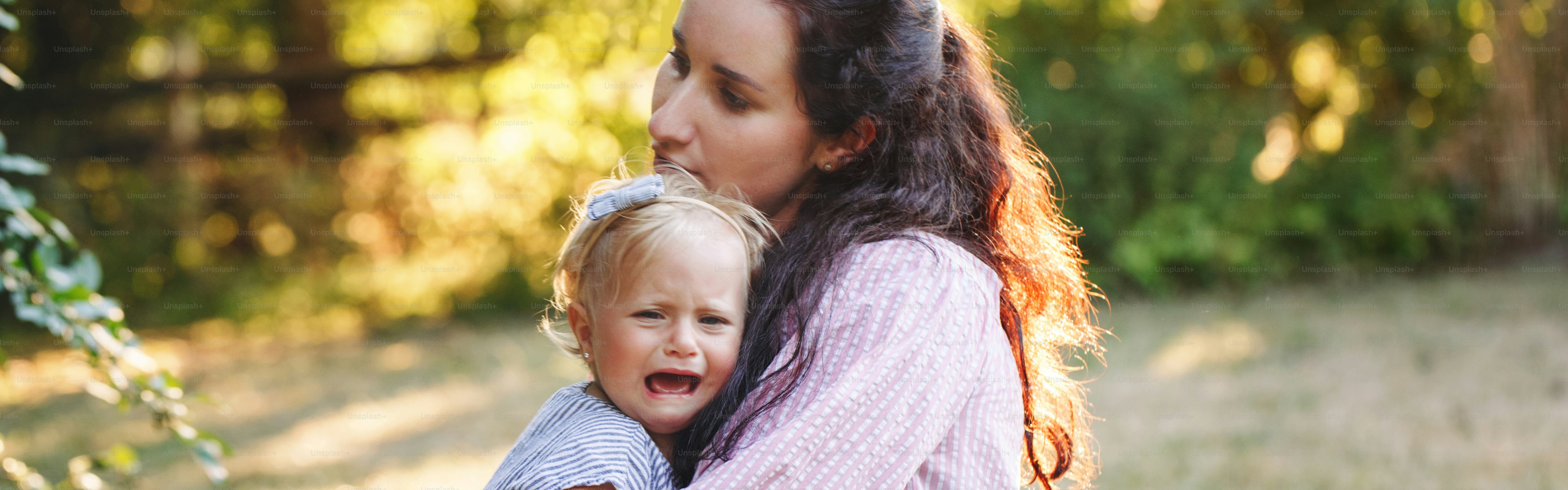 Mother hugging pacifying sad upset crying toddler girl. Family young ...
