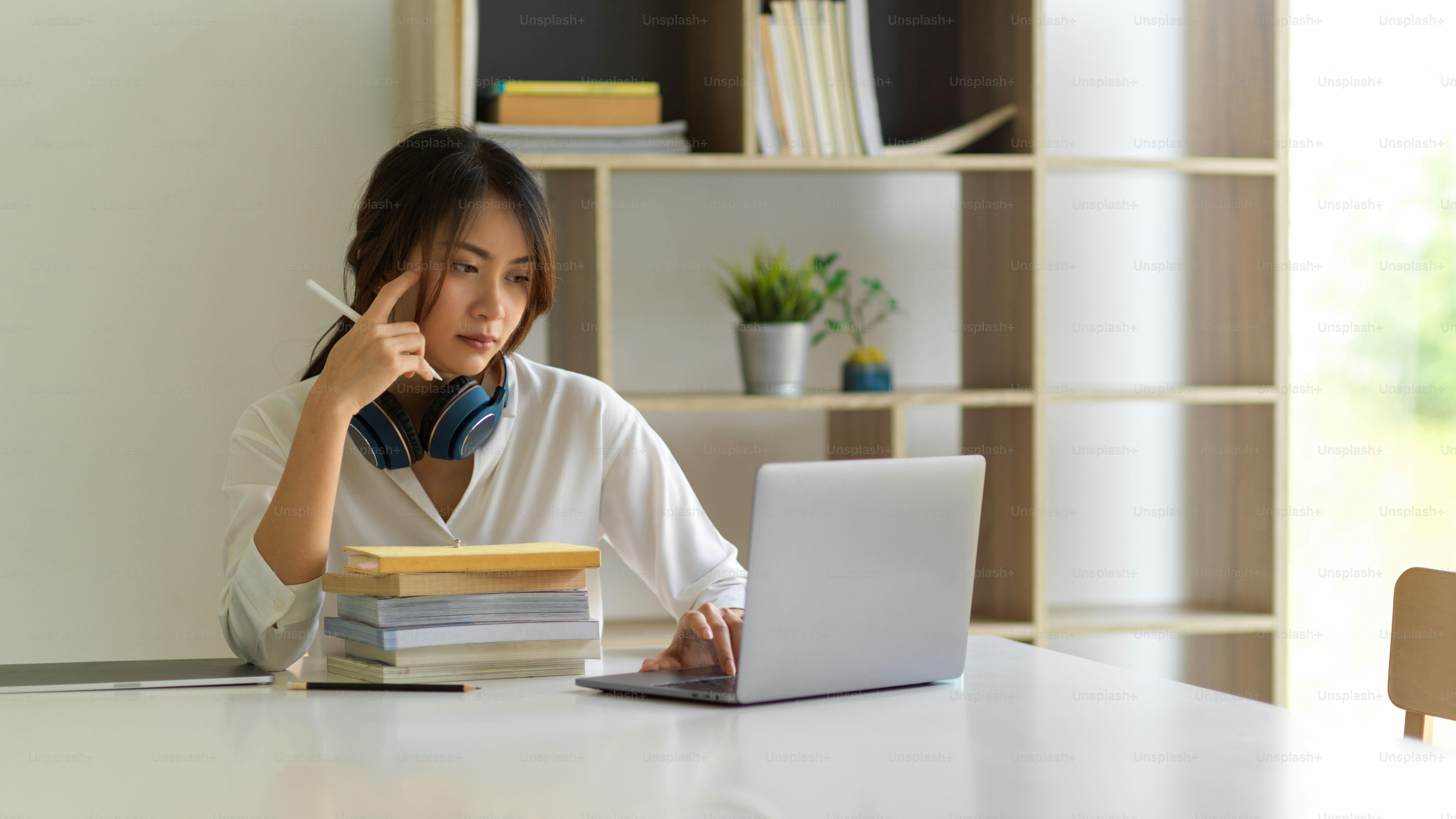 Portrait of female university student concentrating on her online ...