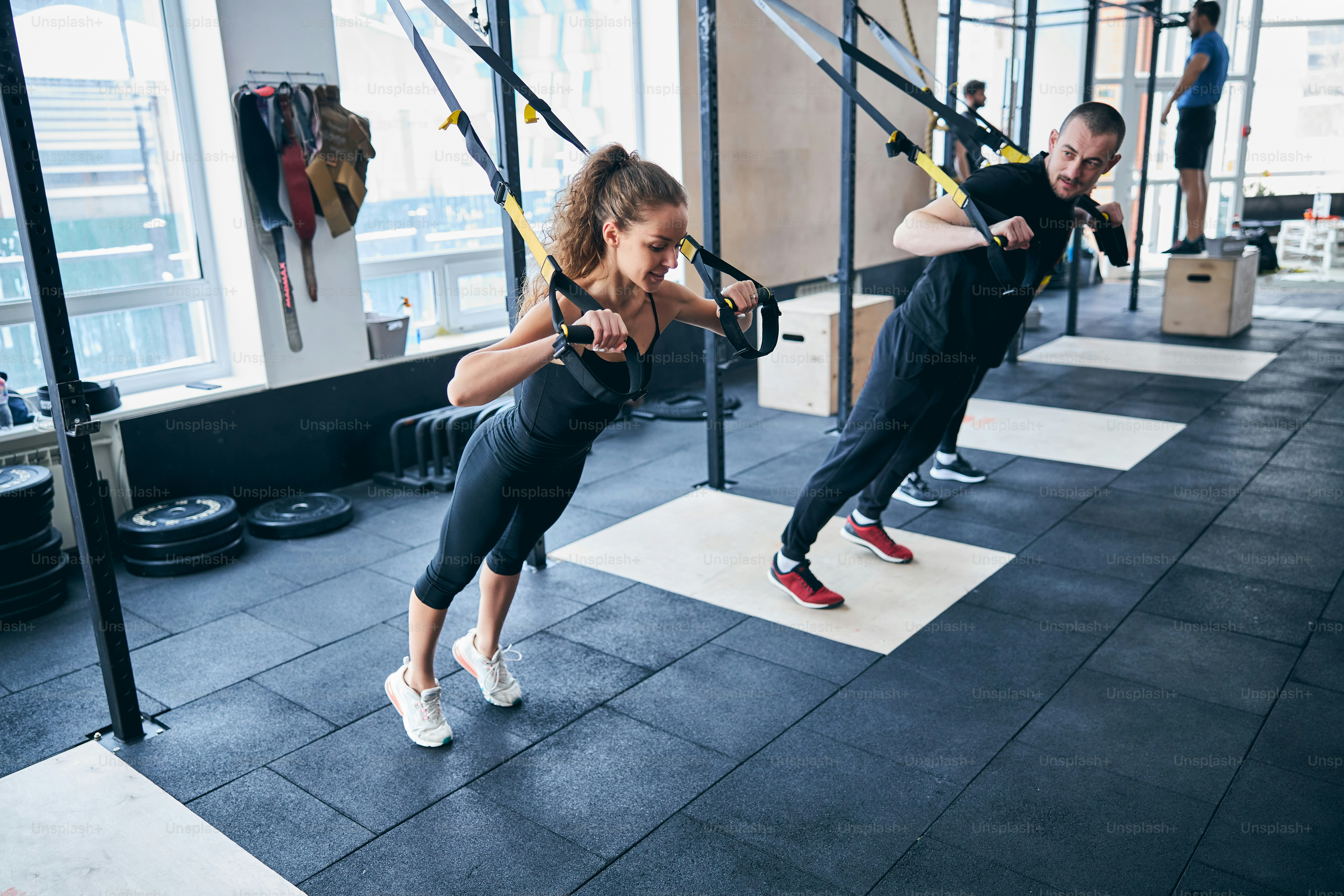Two athletes with their torsos lowered towards the floor and bent ...