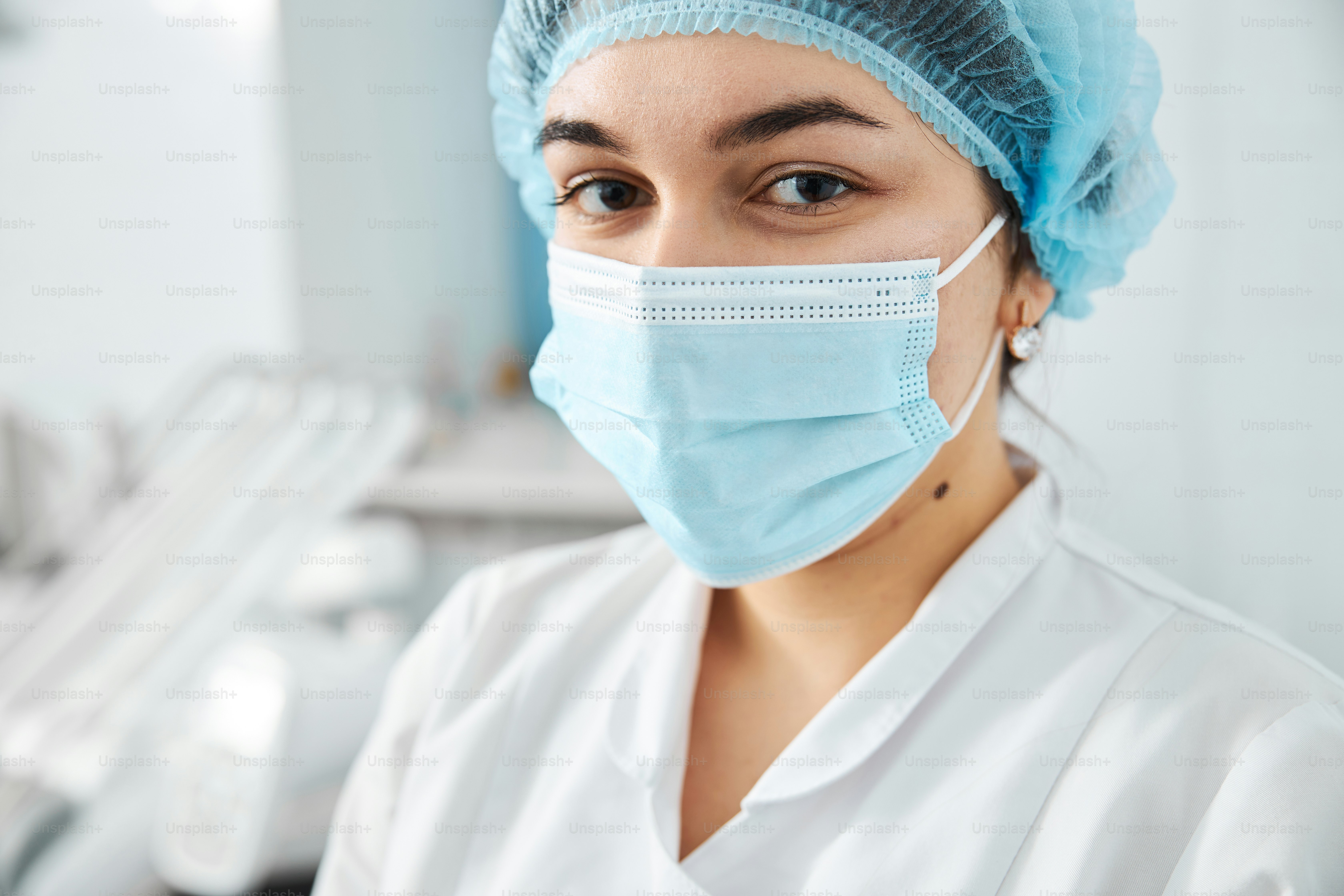Female medical specialist wearing safety facial mask and bouffant cap ...