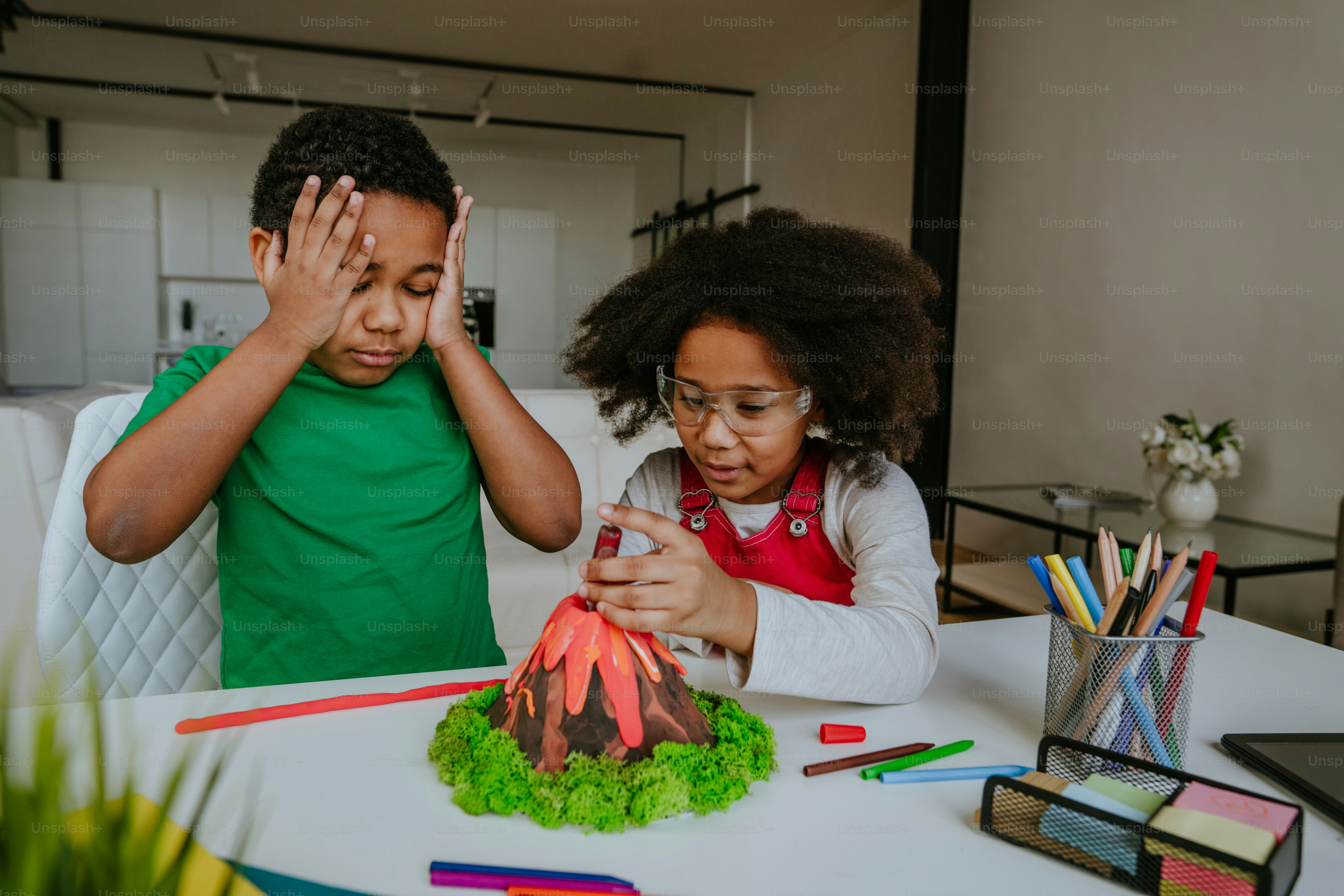 Sister and brother having fun making DIY volcano model from kids play ...