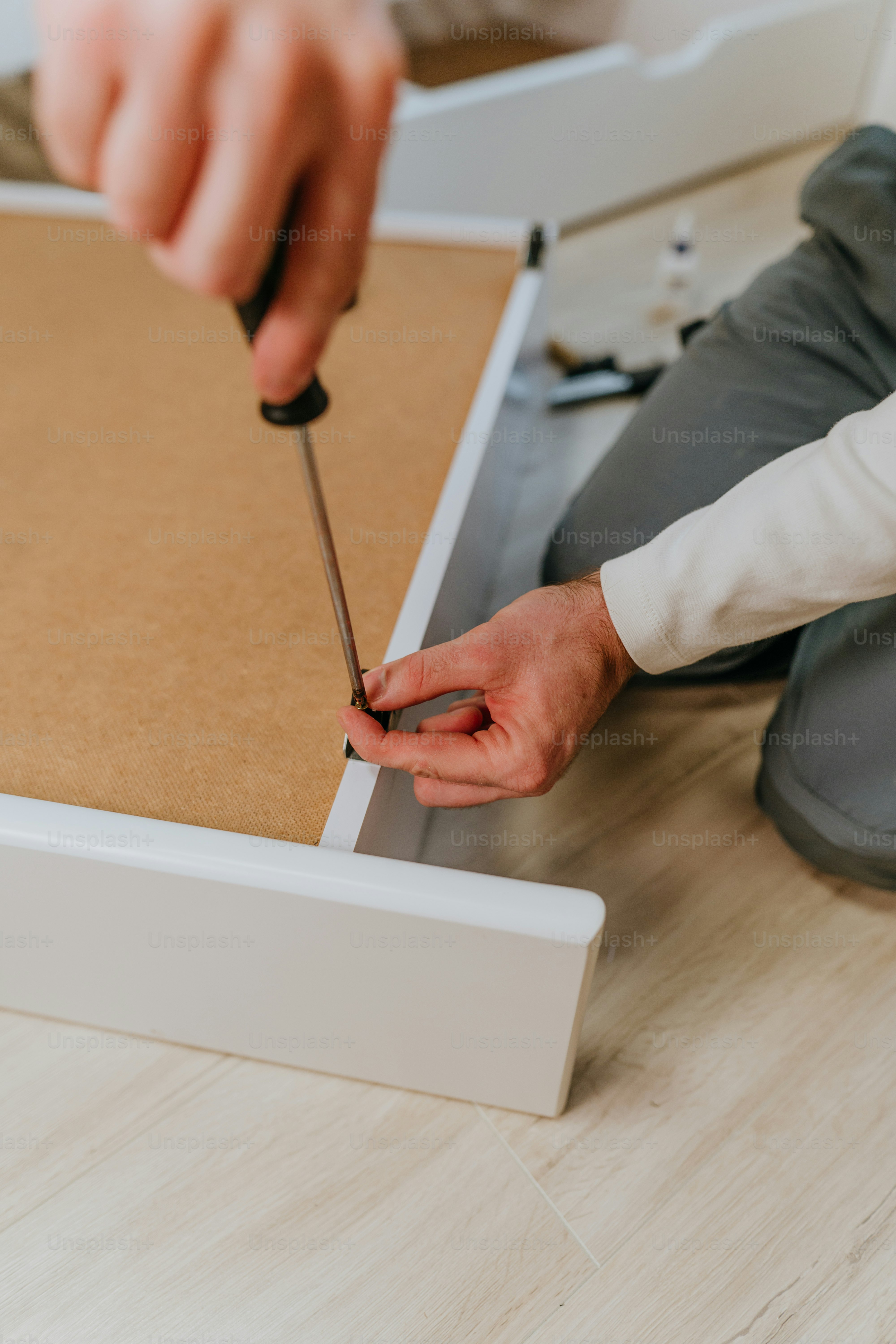 Close-up of male hands twisting the screw with a screwdriver in a ...