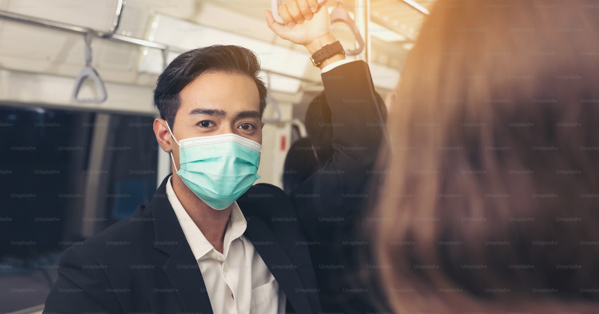 기차에 탄 사람들은 바이러스 백신 마스크를 착용하고 러시아워에 여행합니다 스카이 트레인 내부의 승객들은 모든 사람들의 얼굴에