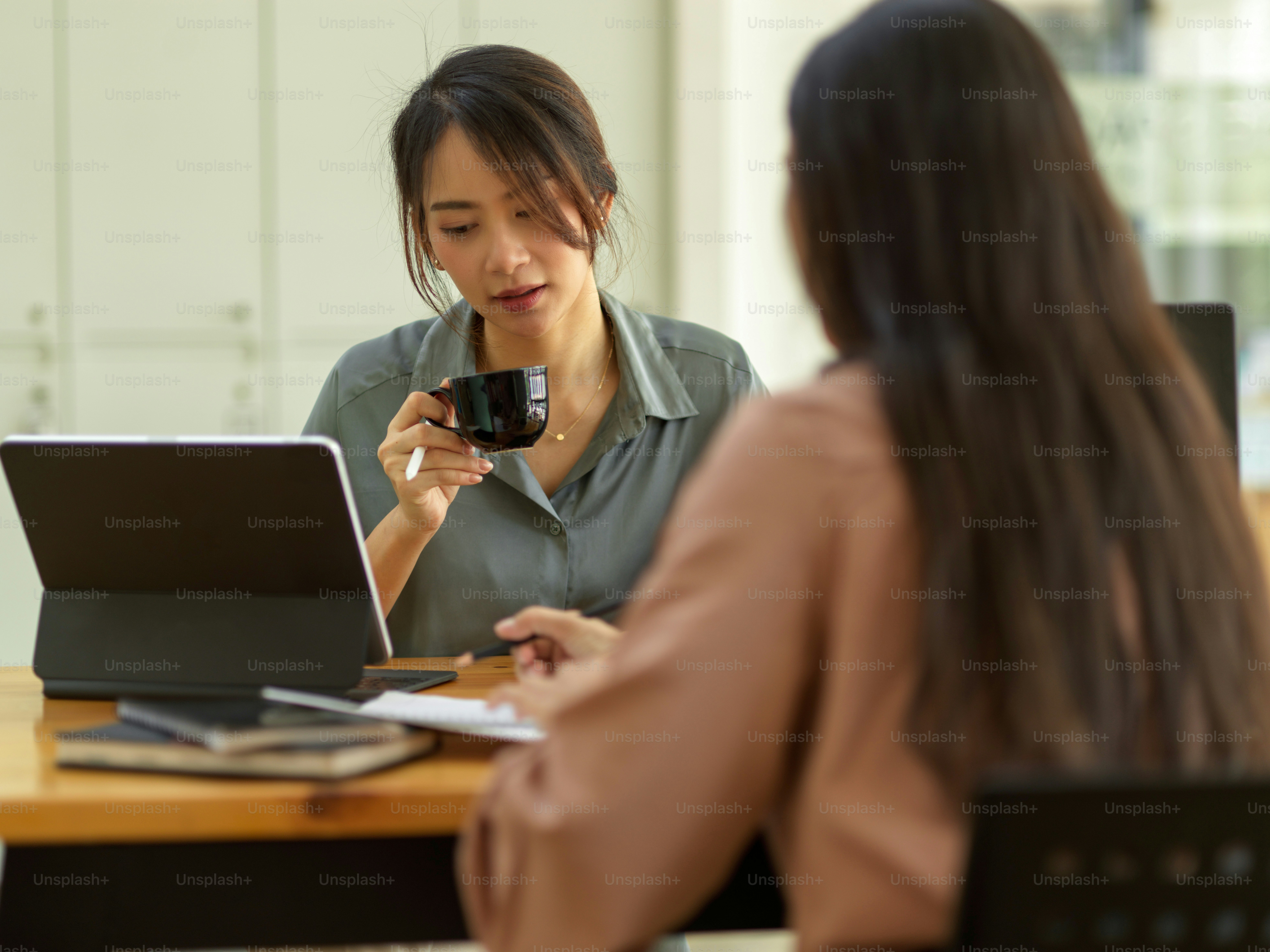 Close up view of two female office workers working together while ...