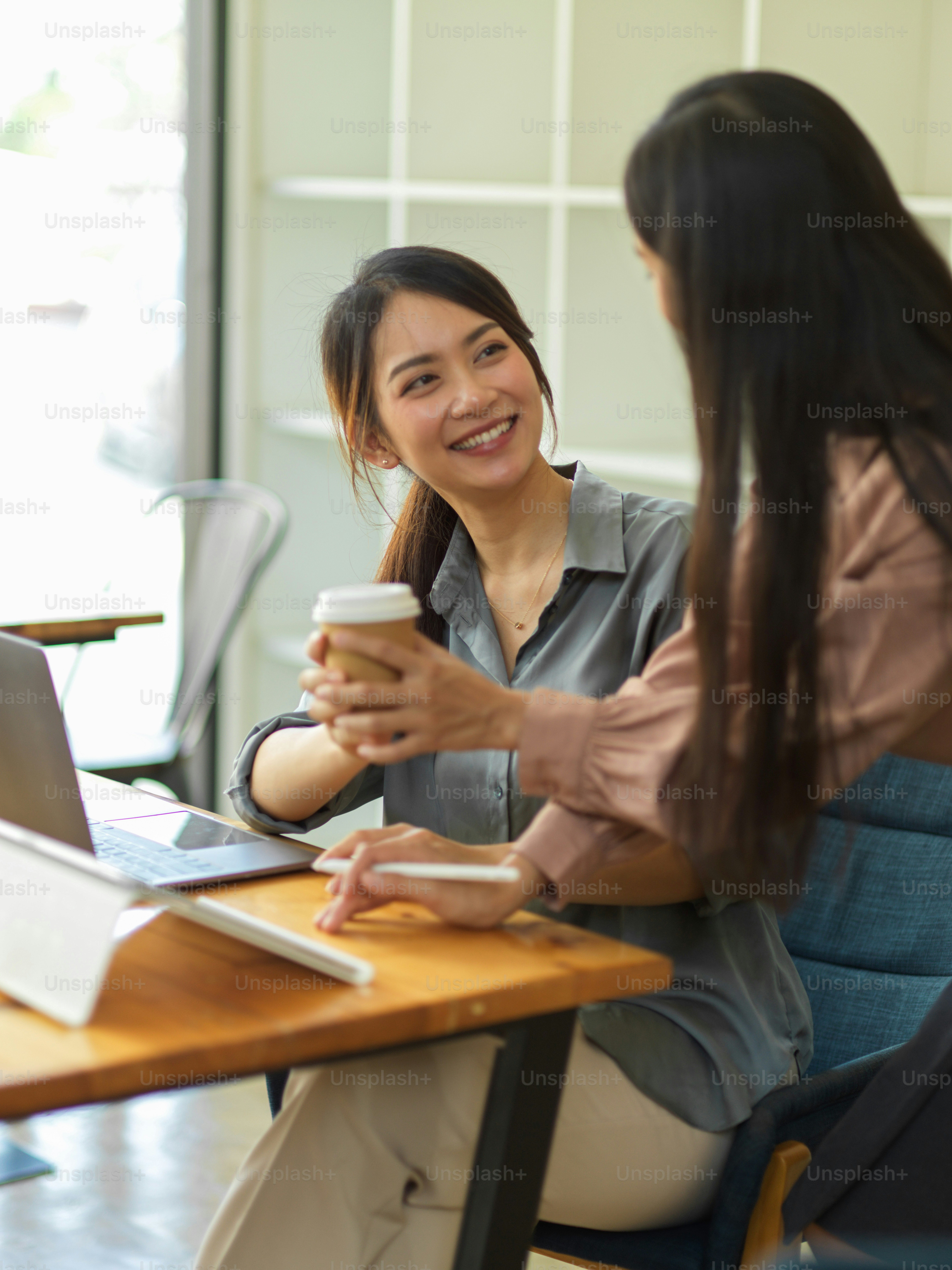 Cropped shot of kindly female office worker giving coffee to her ...