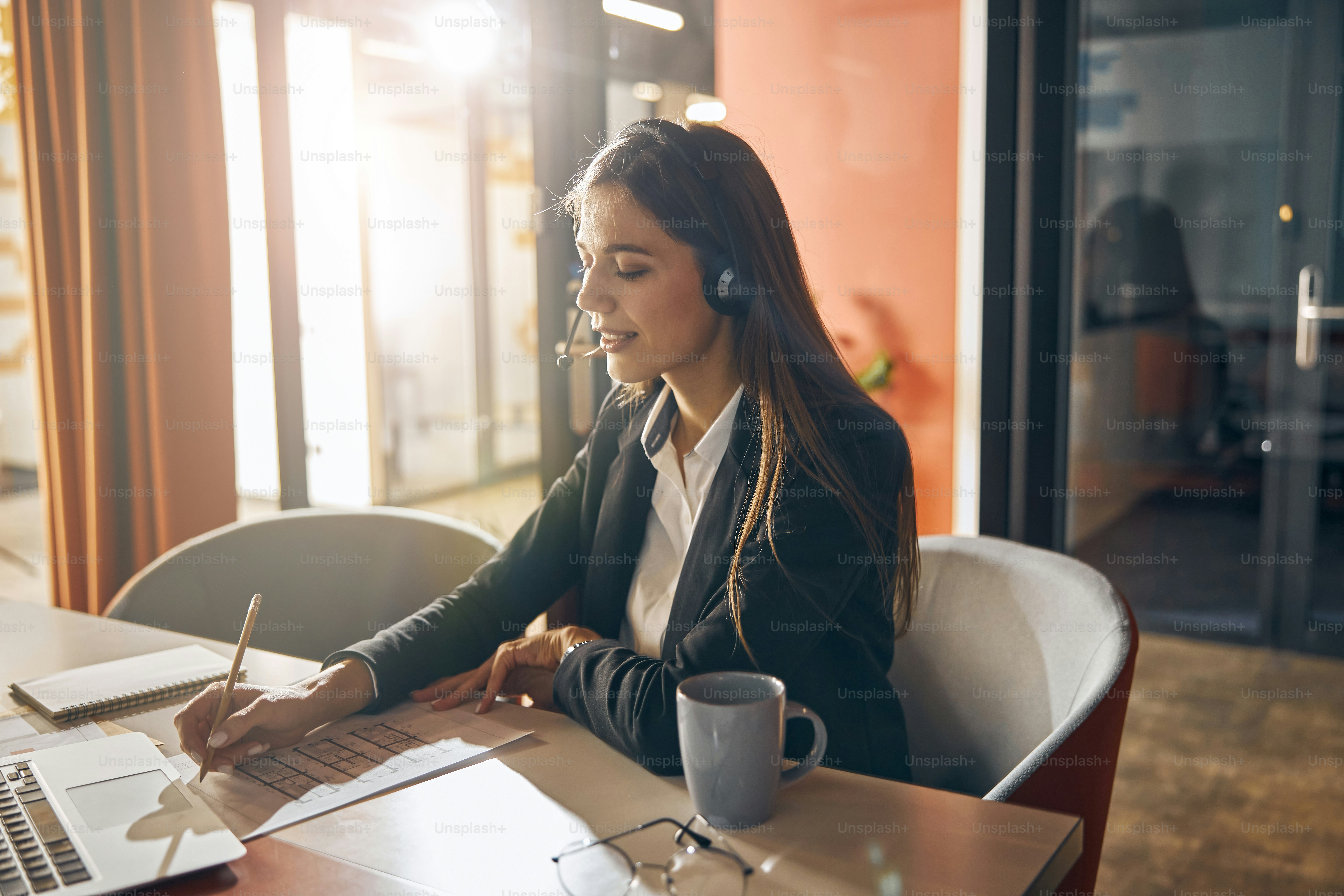 Focused female engineer in wireless headphones working at a technical ...