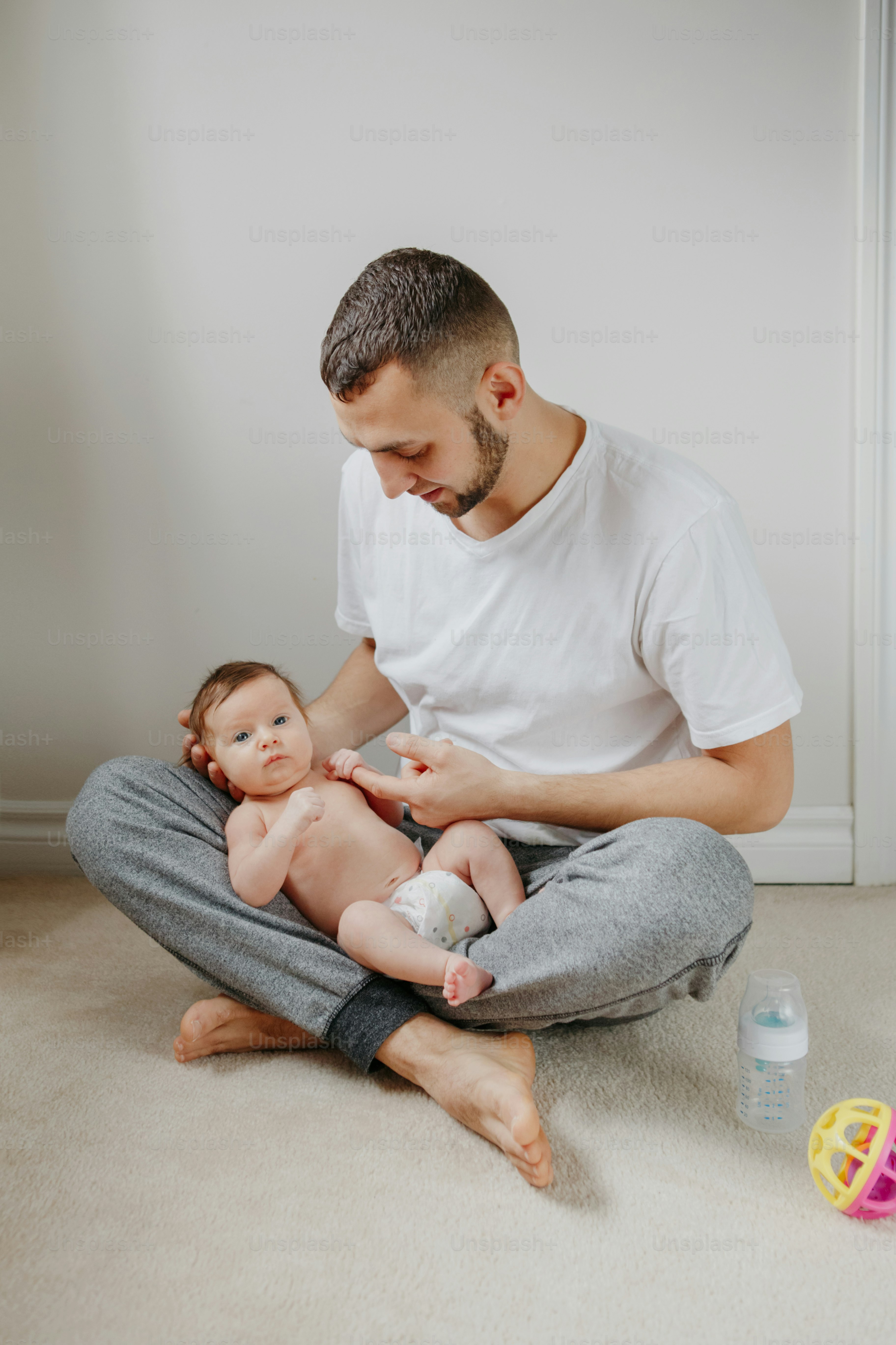 Happy Caucasian father holding newborn baby on laps knees. Man parent ...