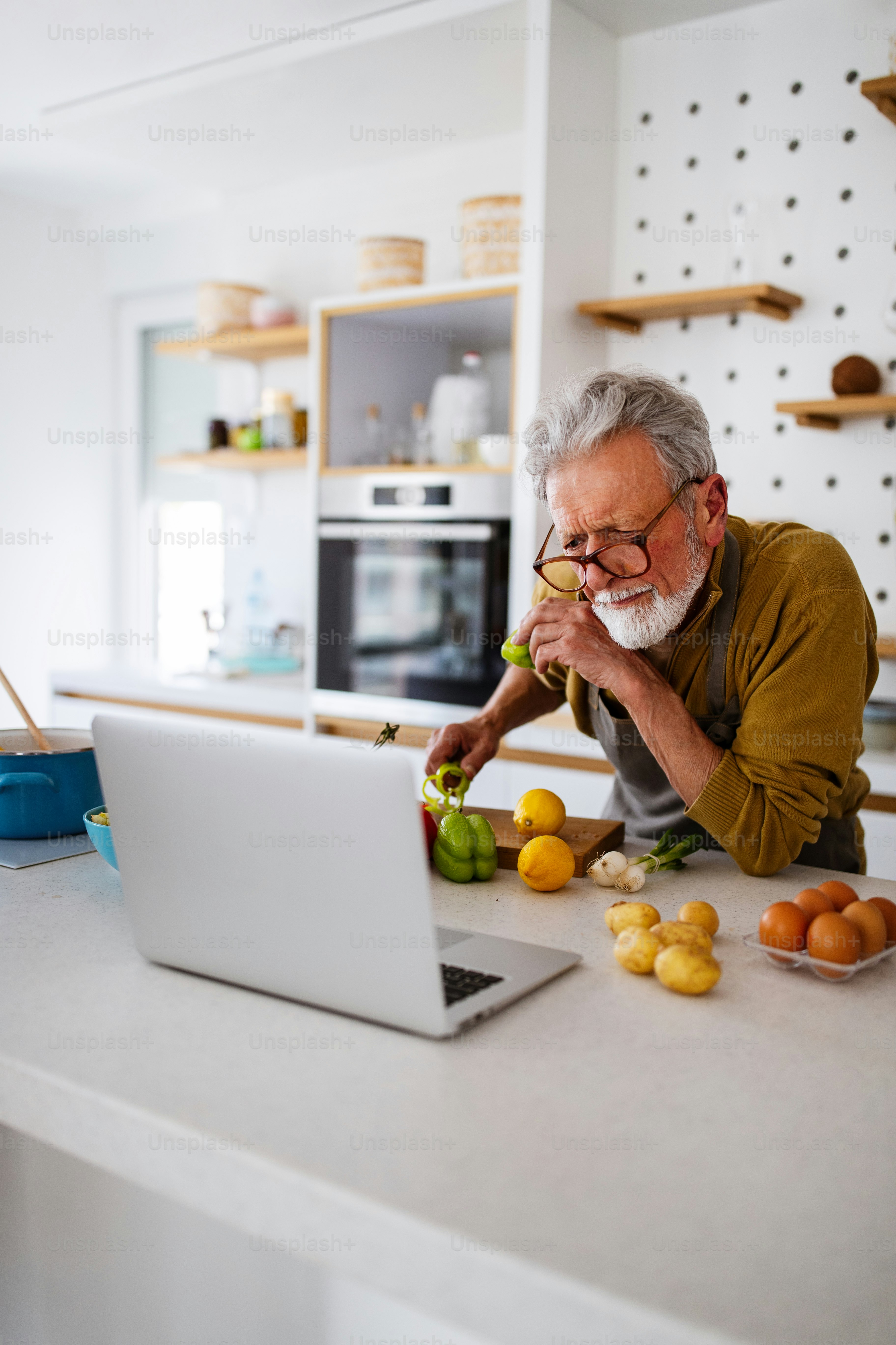 Happy retired mature man cooking in kitchen. Retirement, hobby people ...