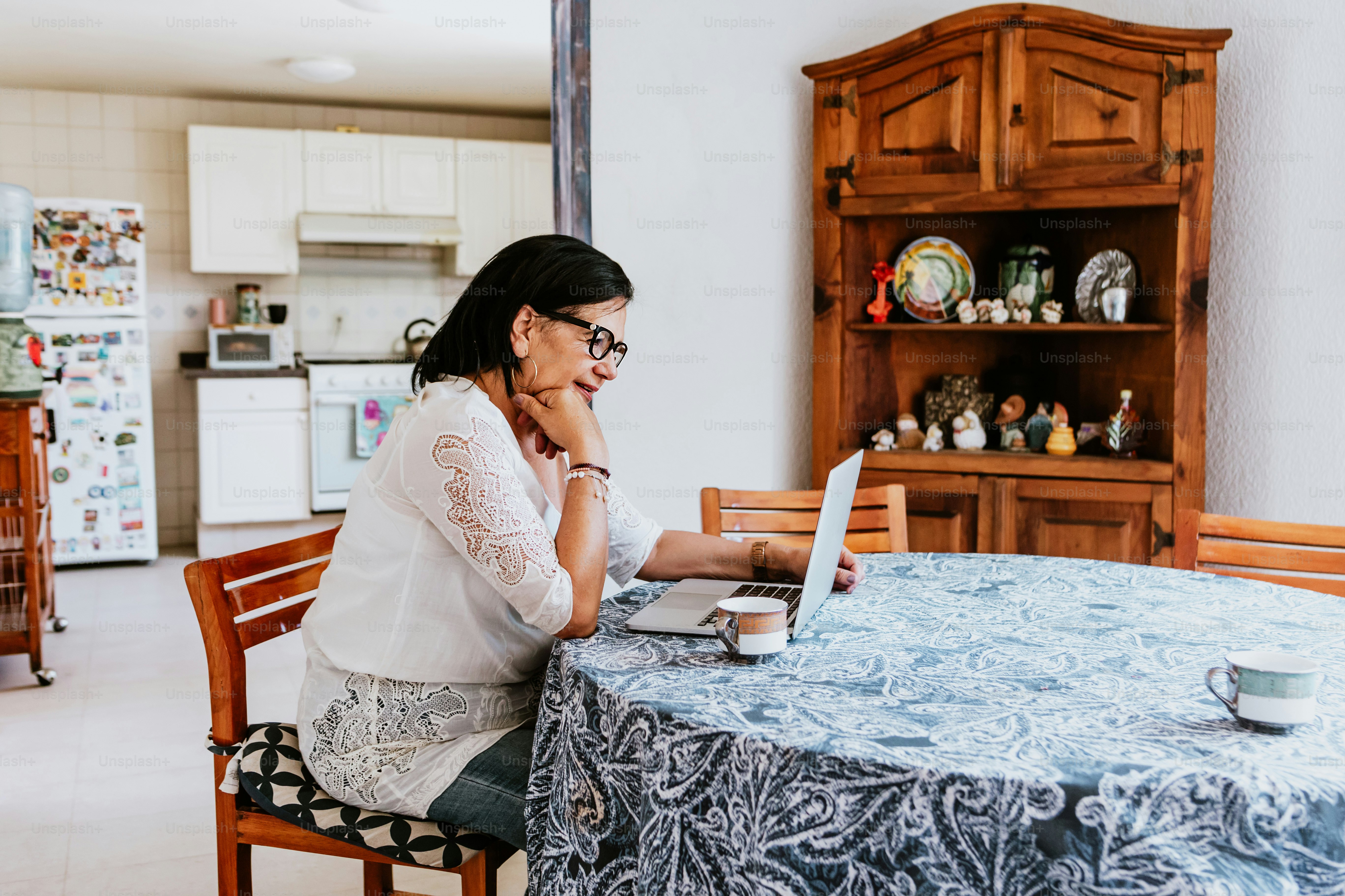 Latin elderly woman working with computer at home in Mexico city photo ...