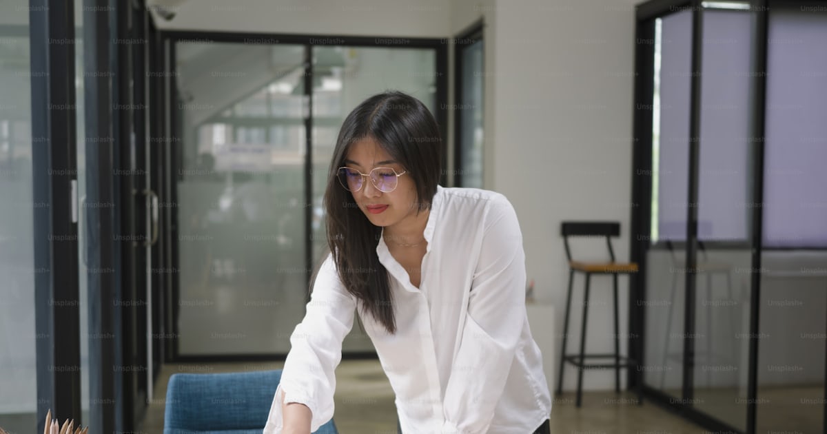 젊은 여성 회사원이 사무실에 서서 노트북 컴퓨터에 타이핑을 하고 있다 사진 Unsplash의 태국 이미지