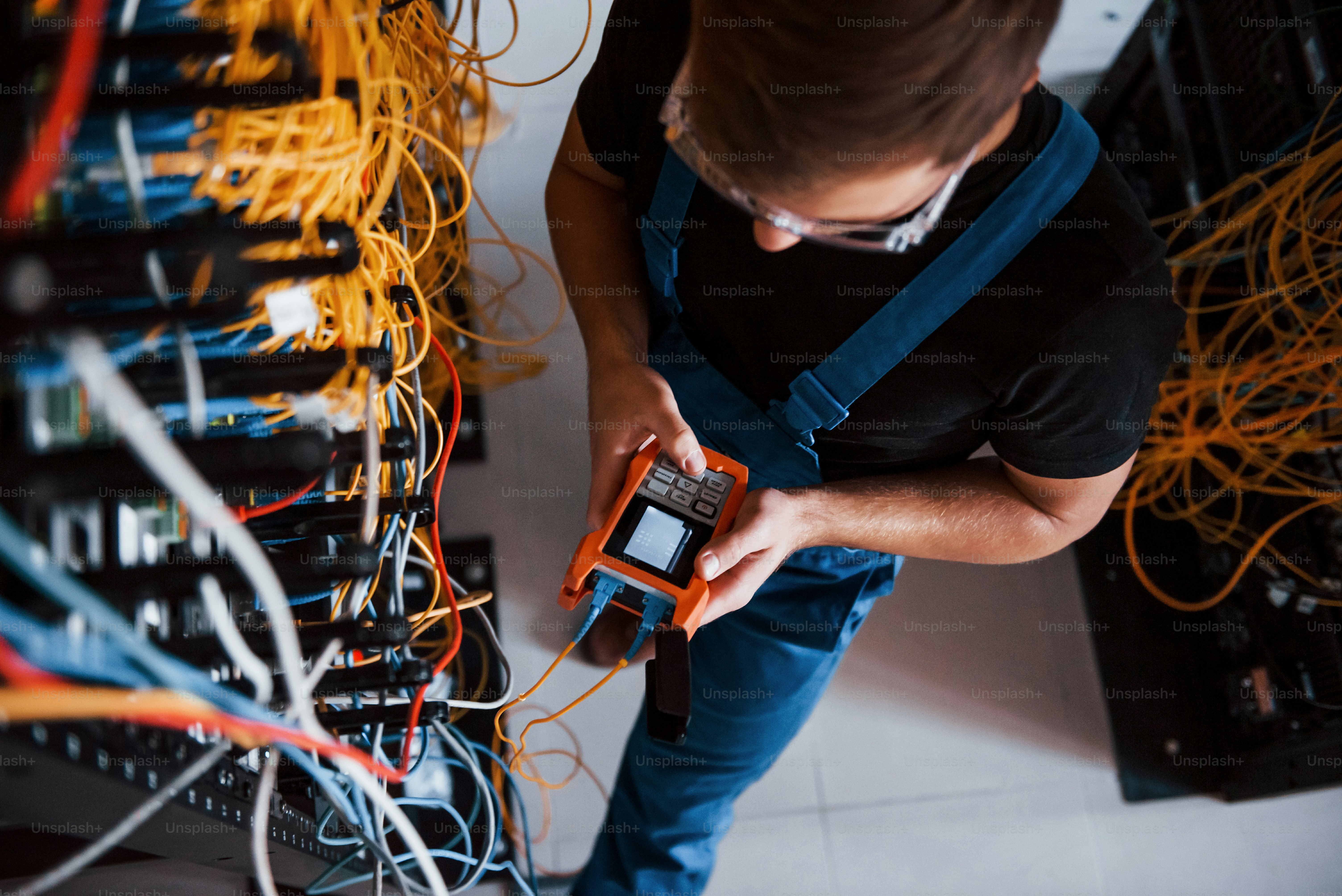 Young man in uniform with measuring device works with internet ...