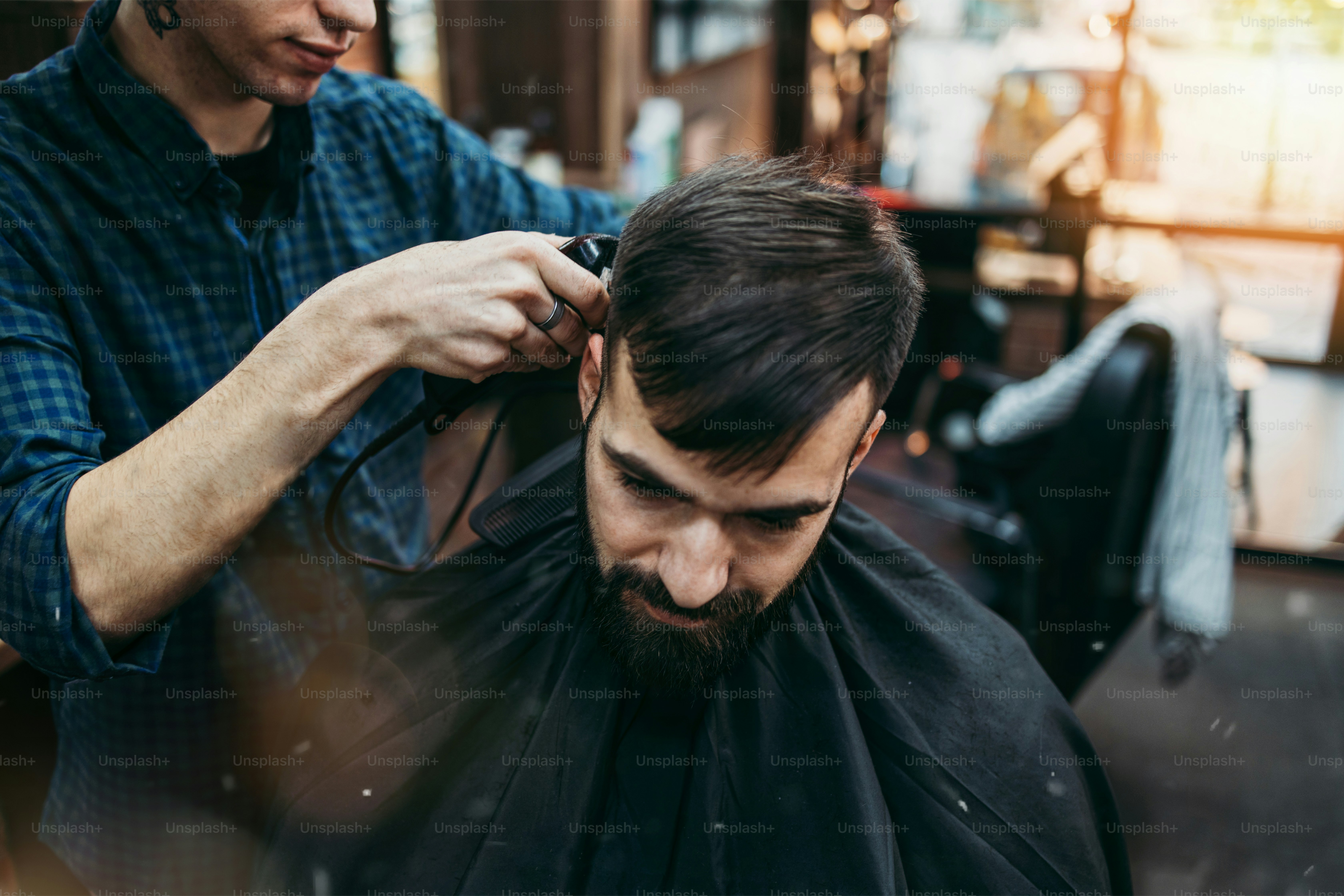 Good looking young adult man getting a hair and beard styling and ...