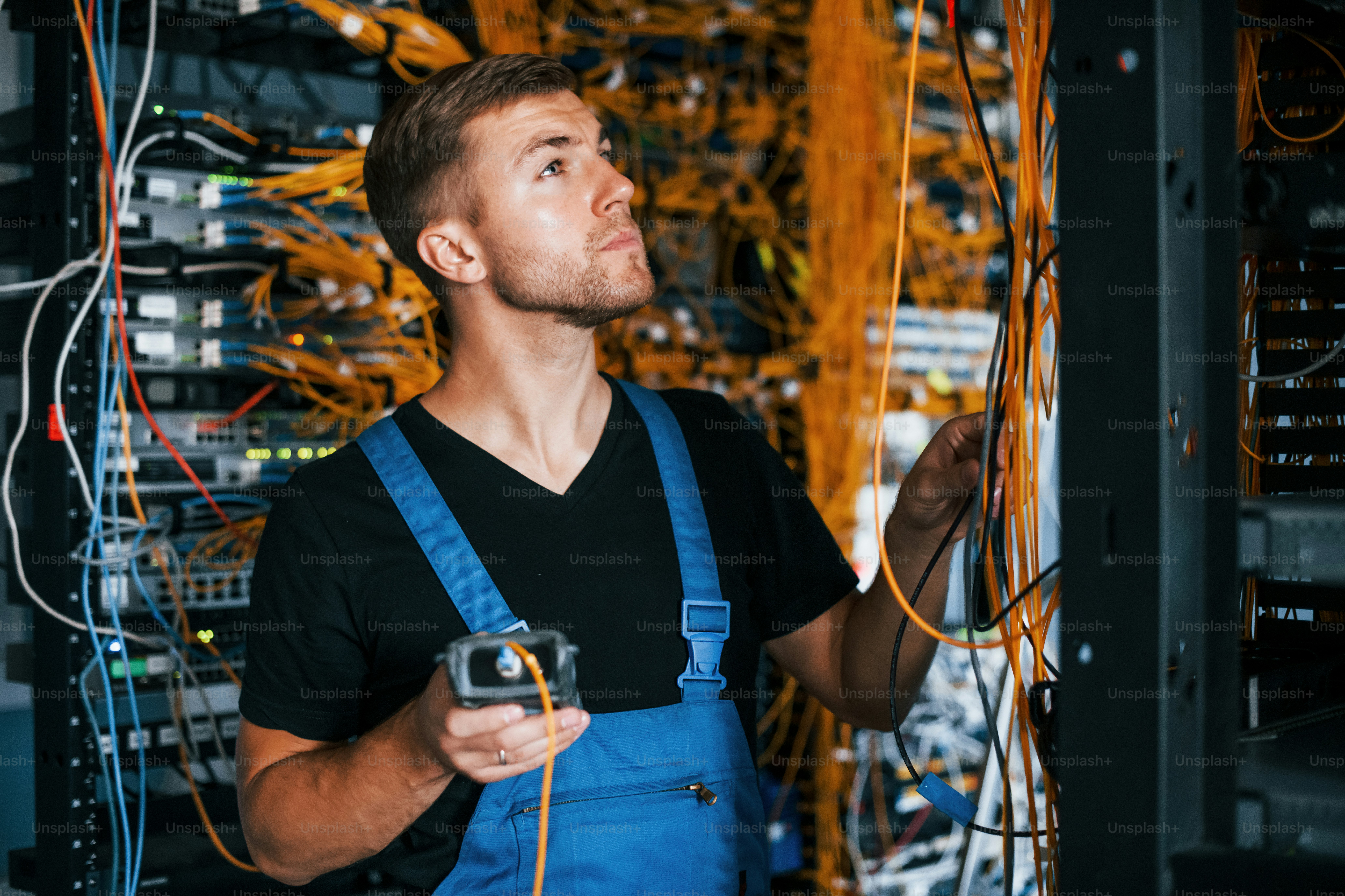 Young man in uniform with measuring device works with internet ...