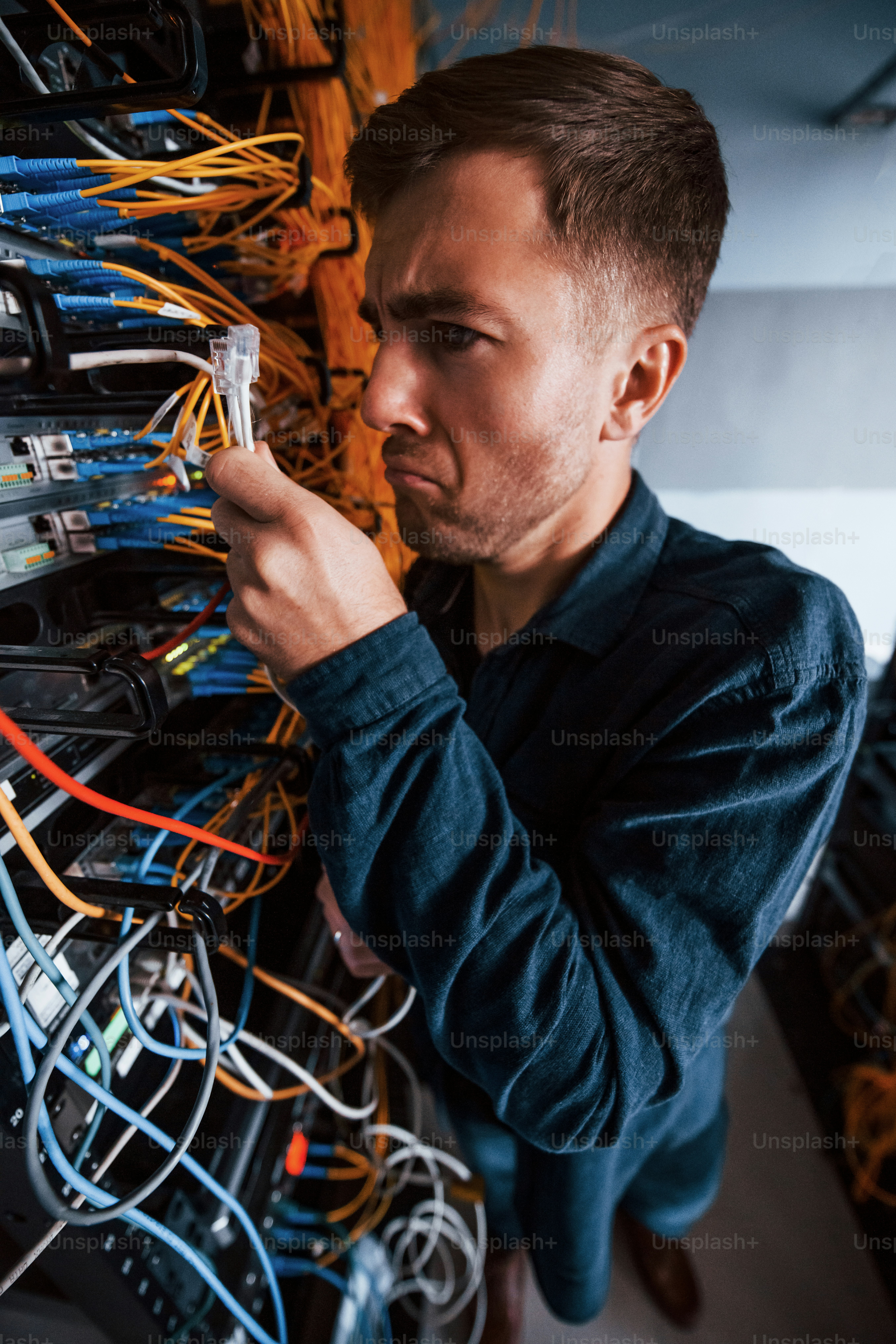 Close up view of funny man with internet wires in server room. photo ...