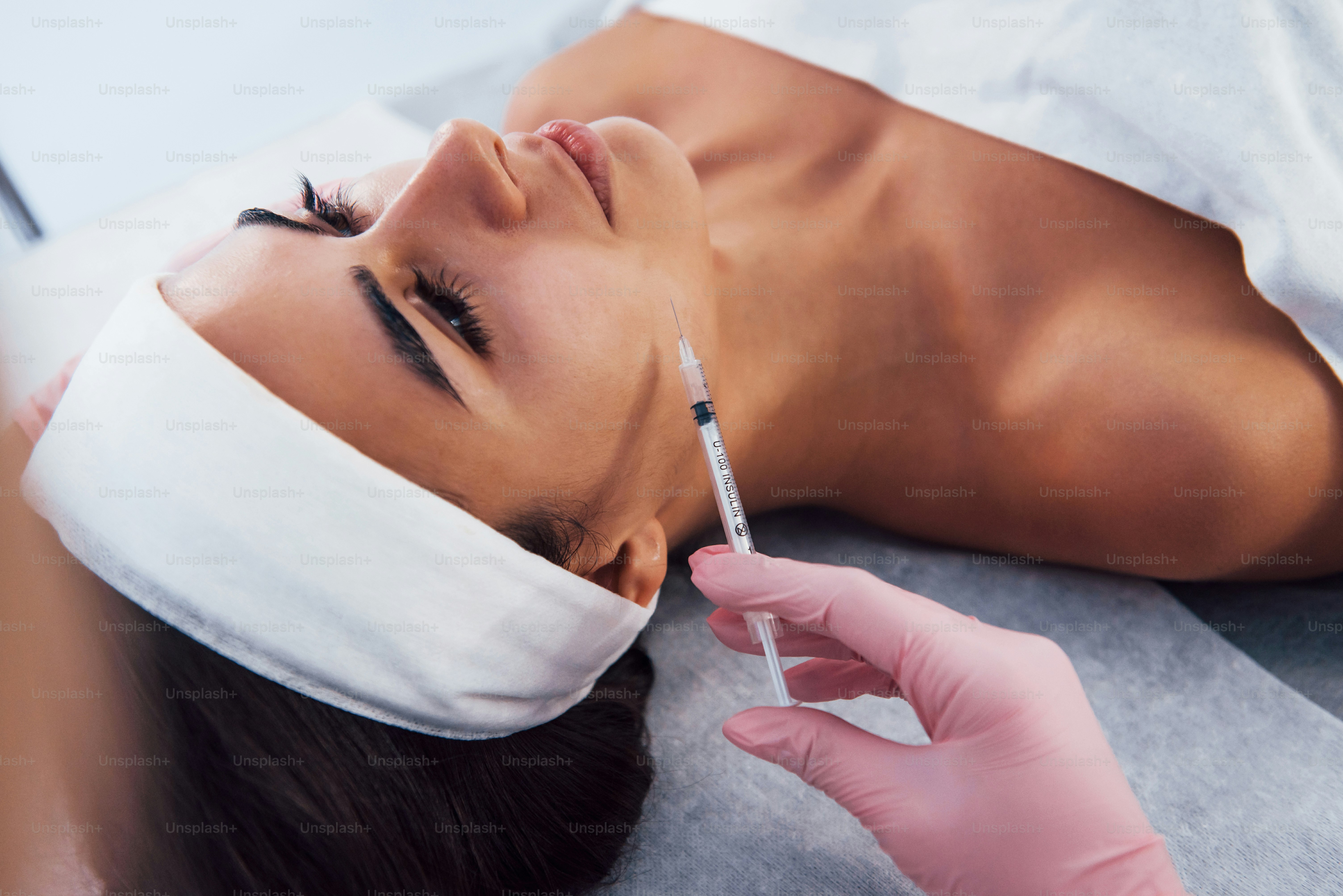 Close up view of woman that lying down in spa salon and have injection ...