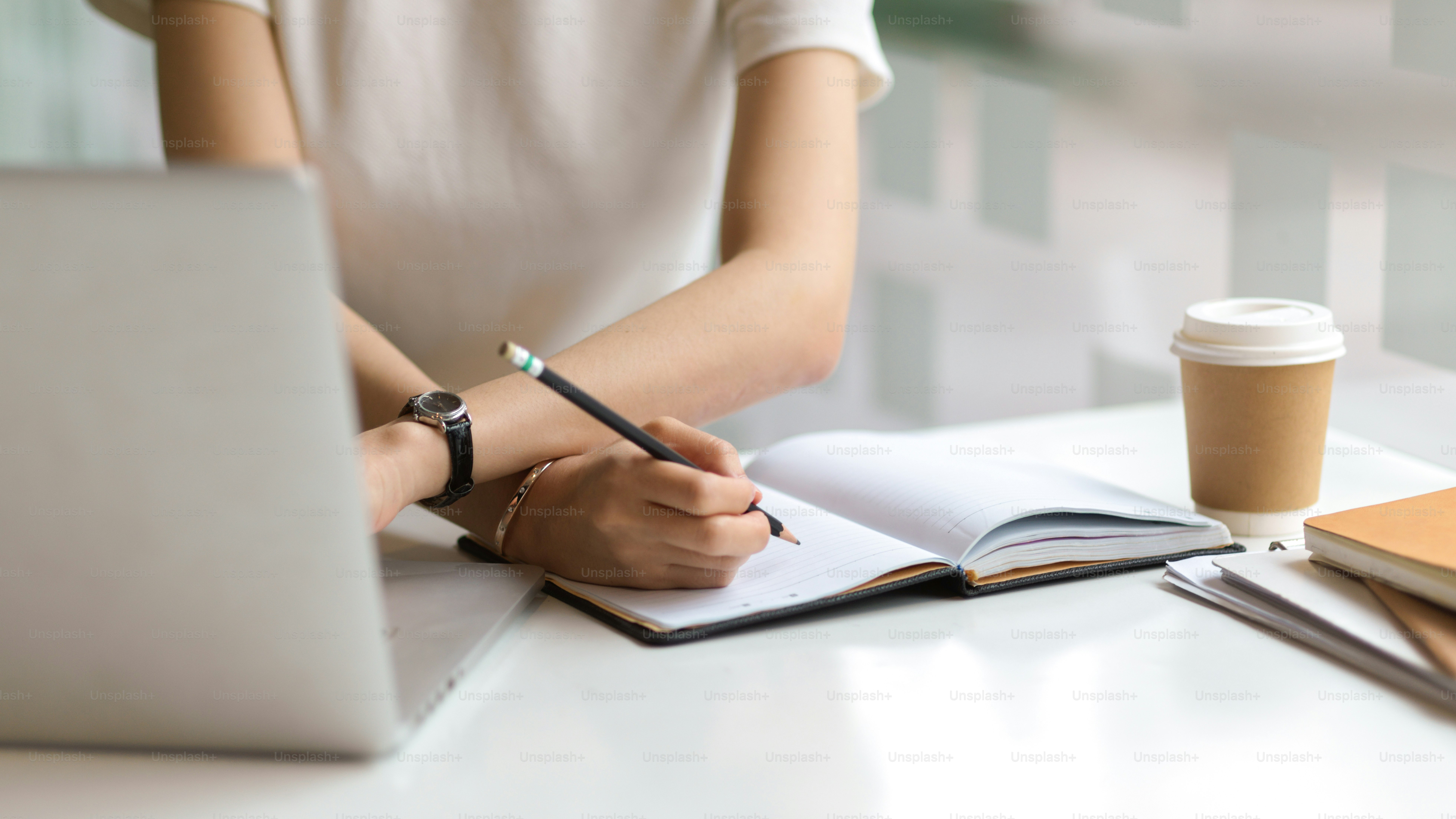 Close up view of female student hand doing assignment with laptop and ...