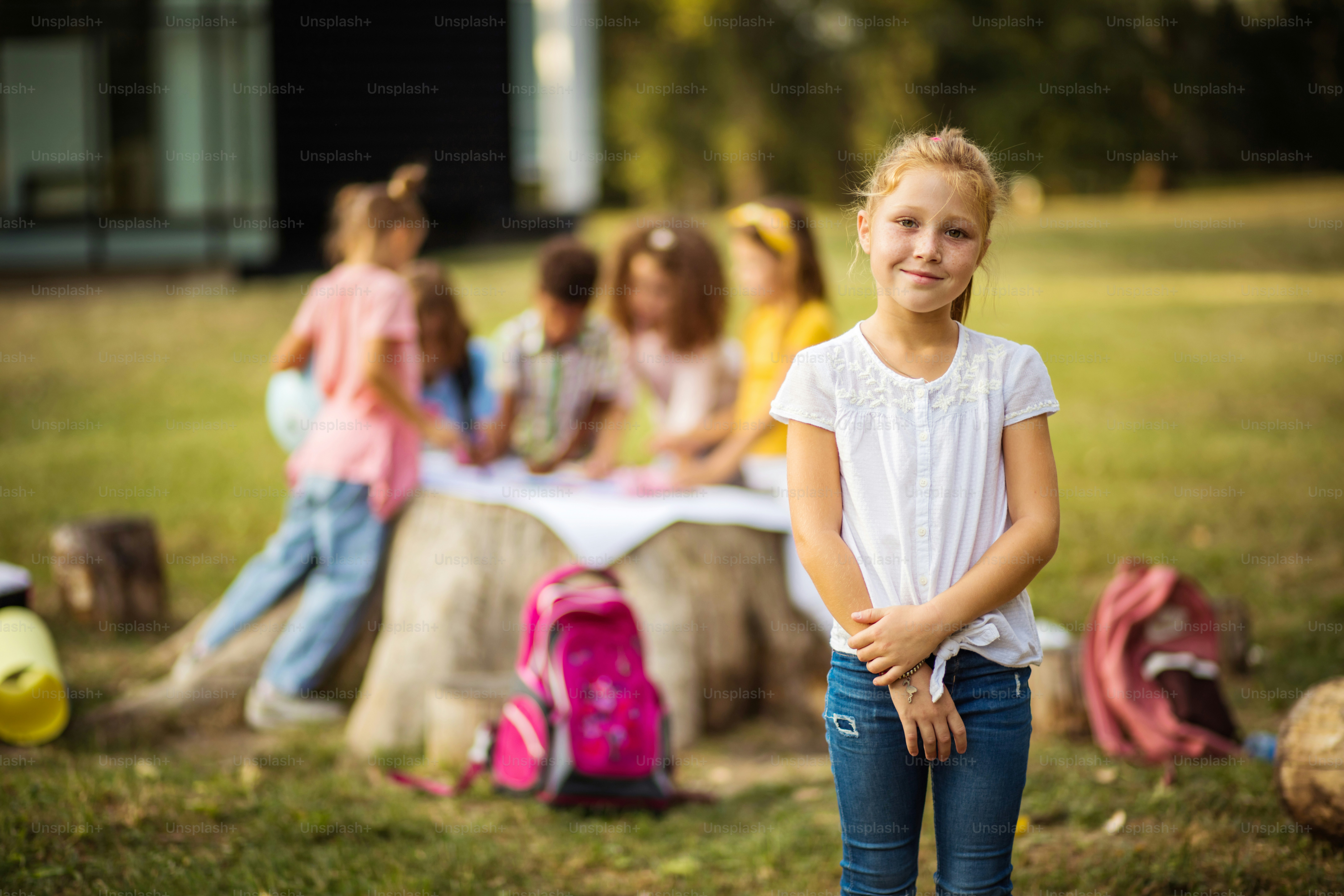 Middle group of school kids having fun in nature. Focus is on ...