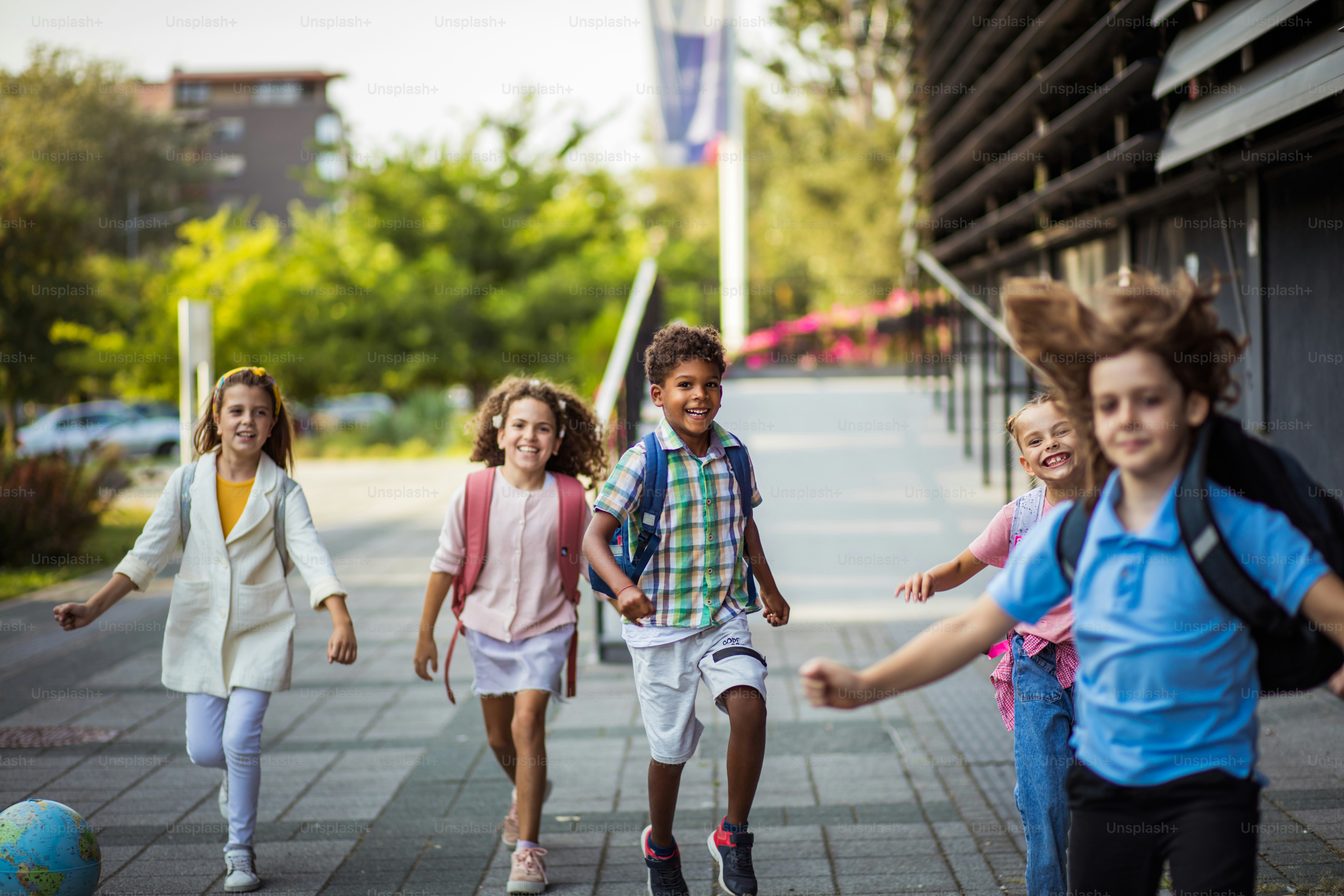 Group of elementary age schoolchildren outside. School kids going to ...