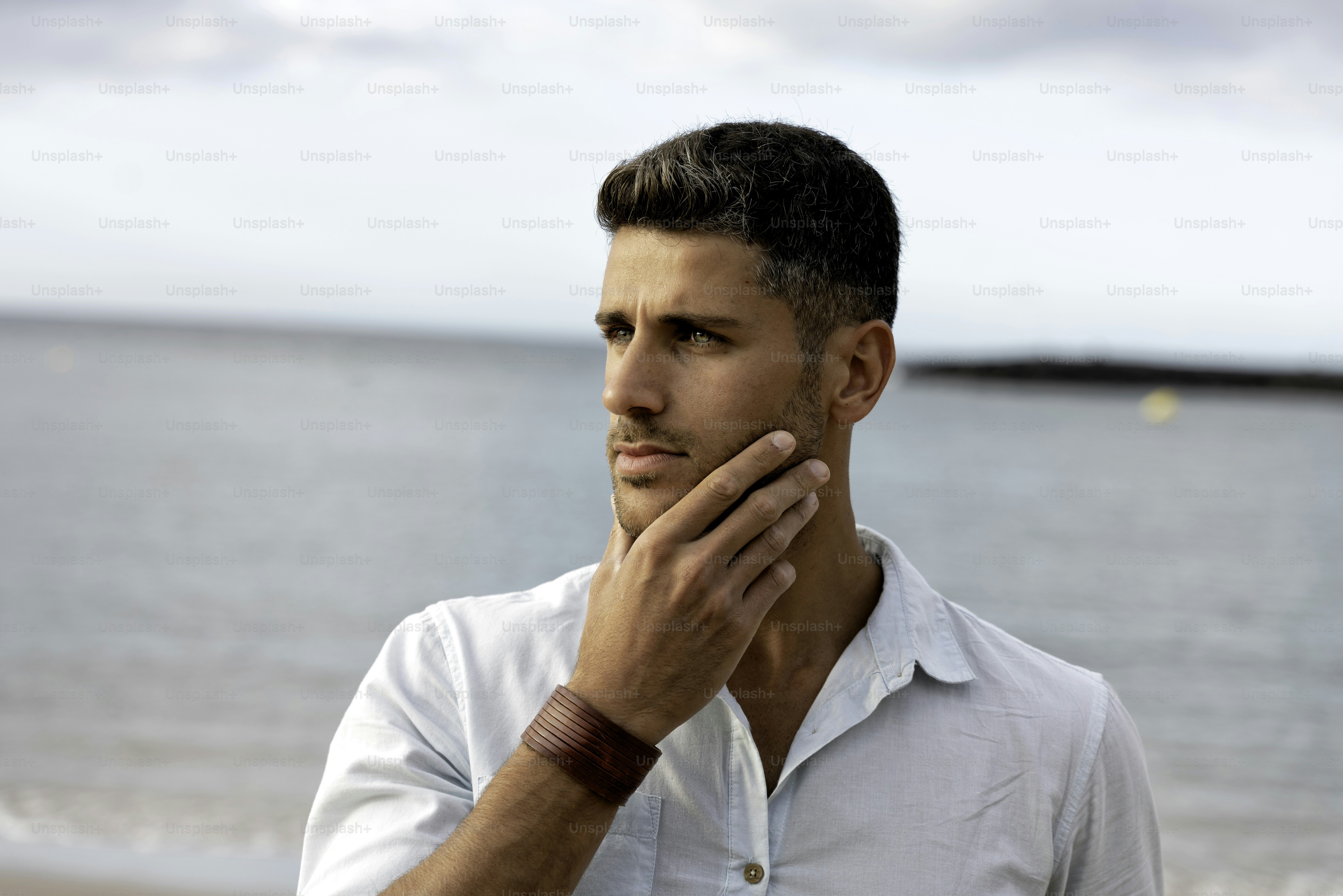 Portrait d’un beau jeune homme italien posant en plein air sur la côte ...