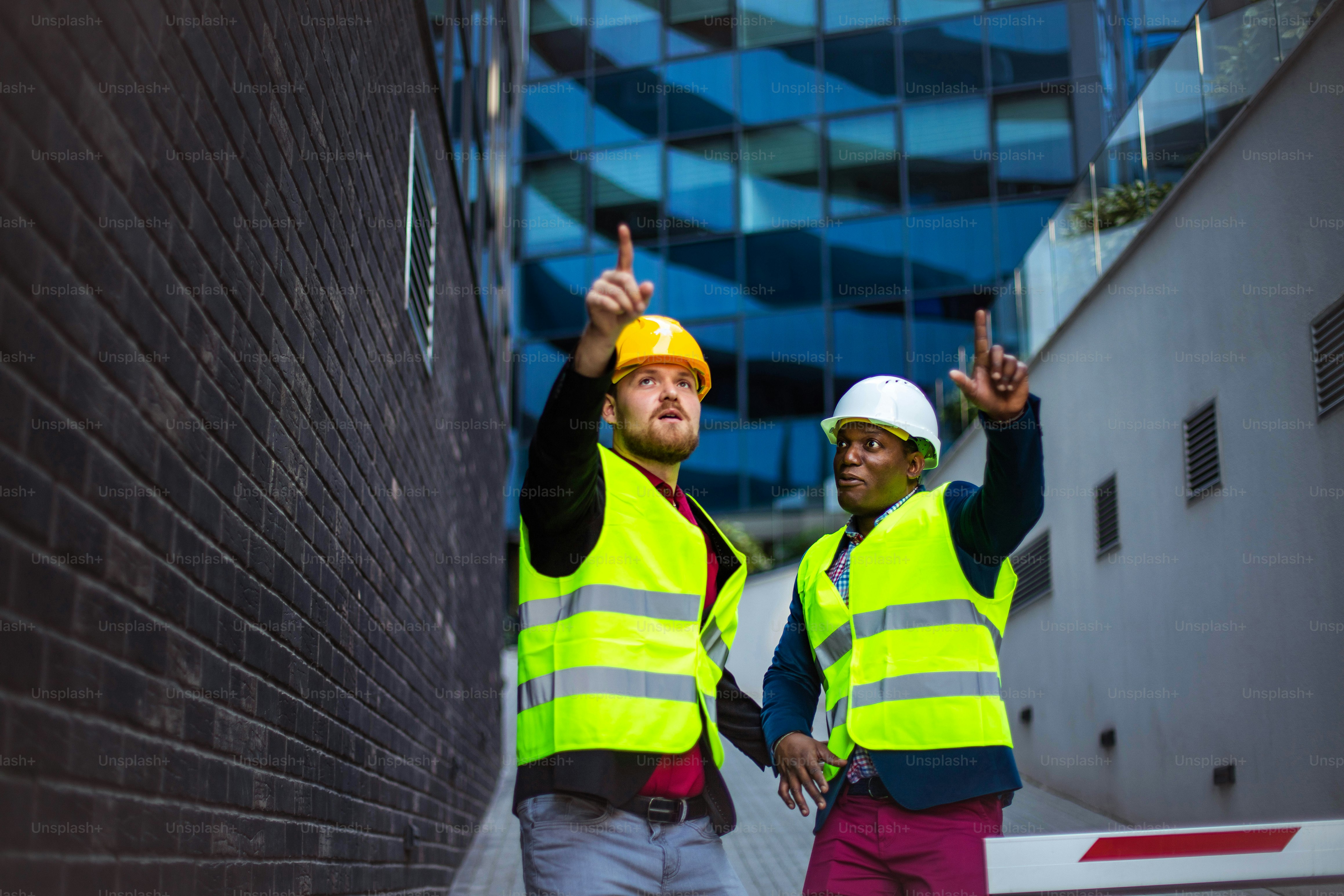 Ingeniero discutiendo la estructura del edificio con un colega arquitecto en el sitio de ...