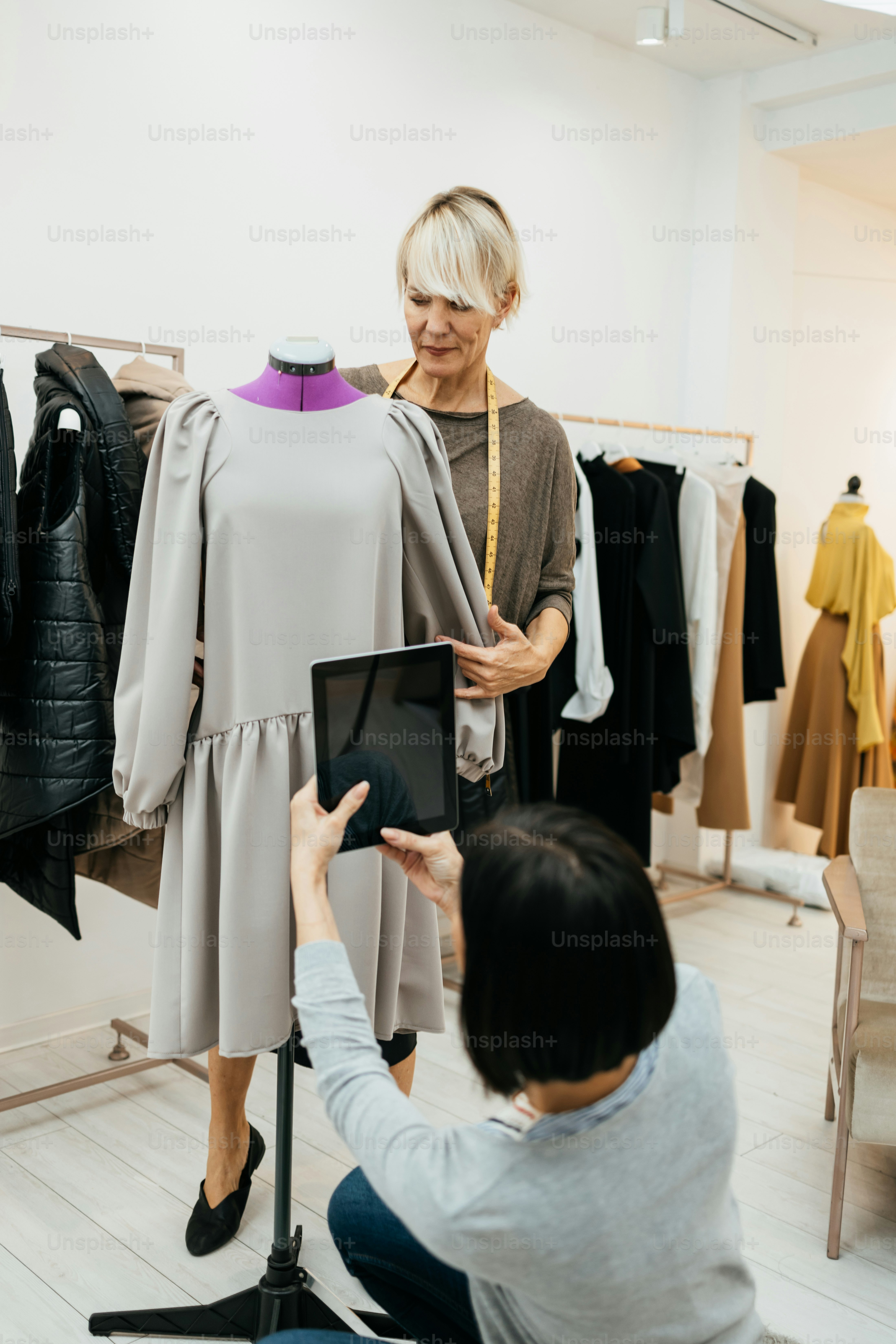 Two professional designers working in fashion studio. Creative people ...