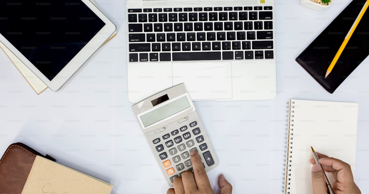 Homme utilisant une calculatrice et écrivant prendre note avec calculer ... Homme utilisant une calculatrice et écrivant prendre note avec calculer ...
