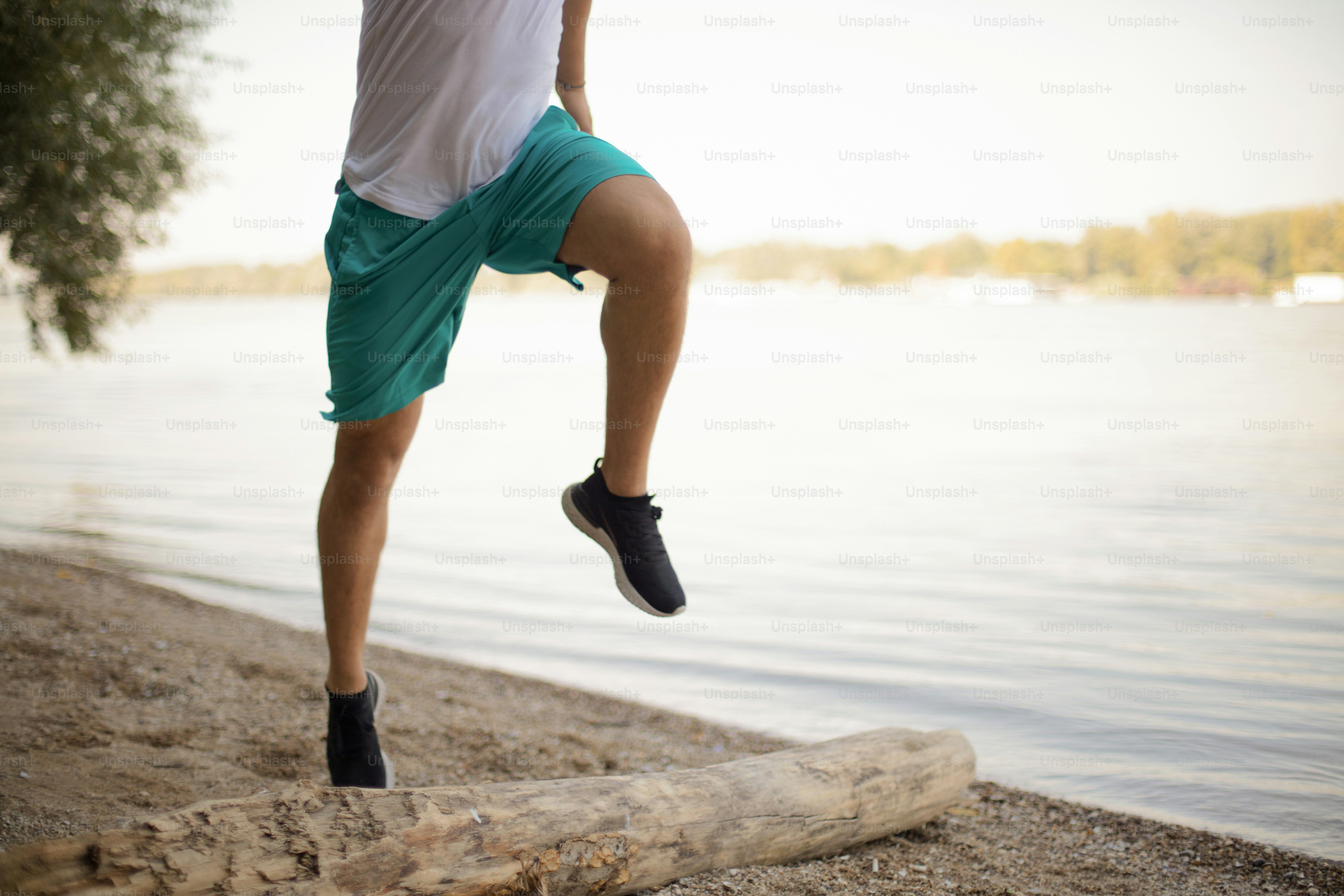 Sports man jumping and having training on the beach. photo – Running ...